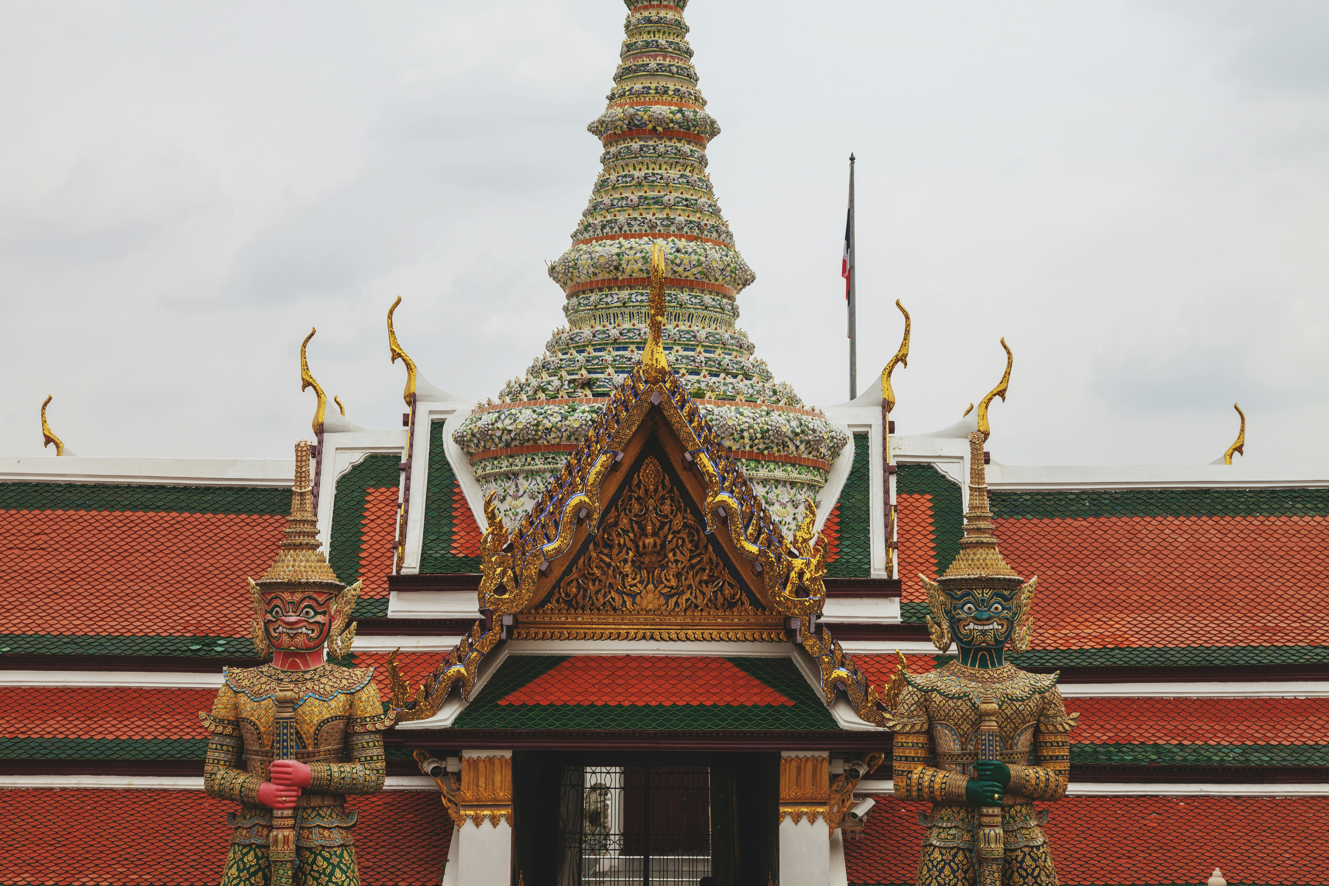 Guardians at the Gate: Thai Temple Spire and Ornate Façade