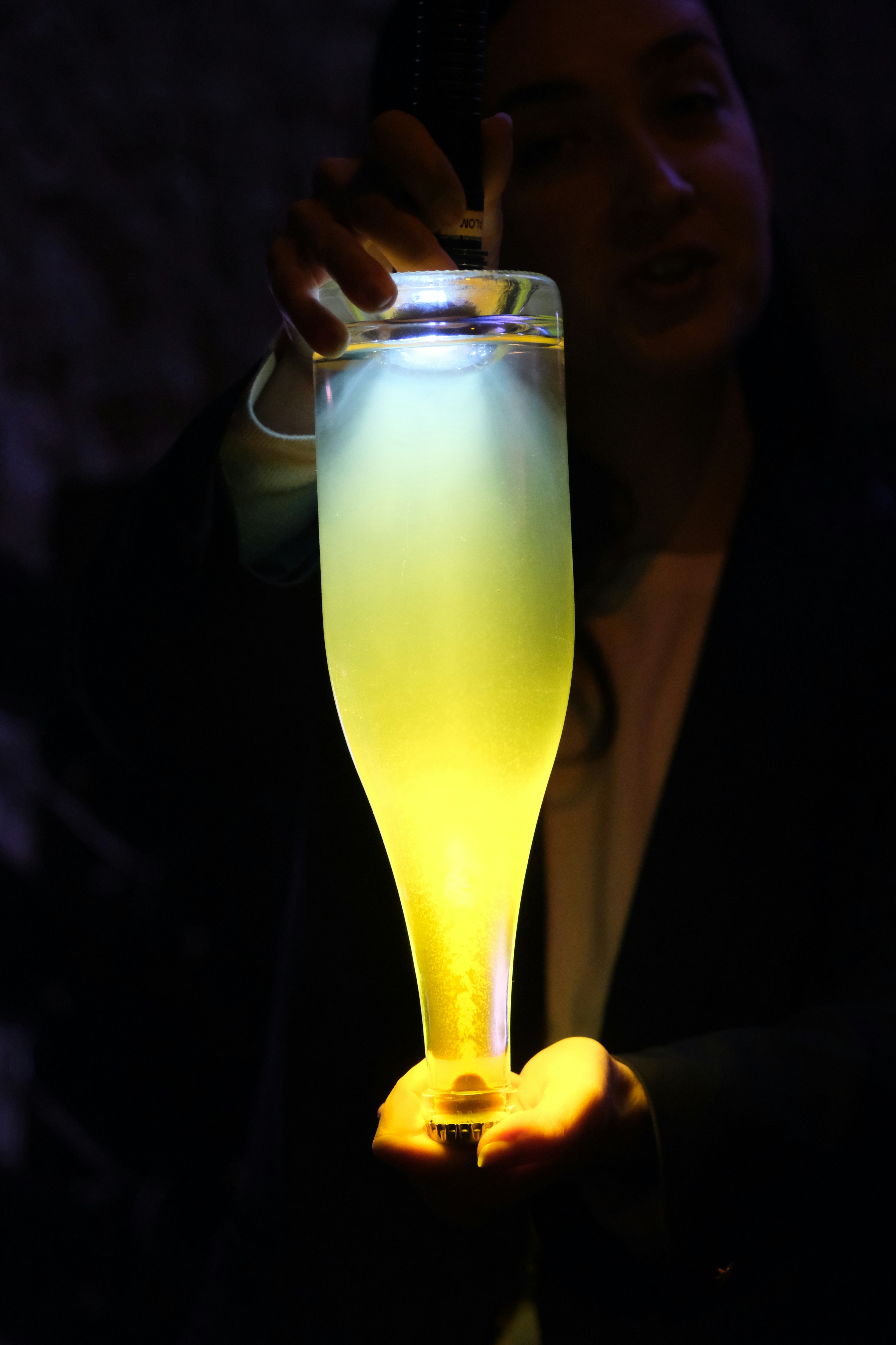 Glow-Tipped Champagne: A Radiant Toast in a Dark Room