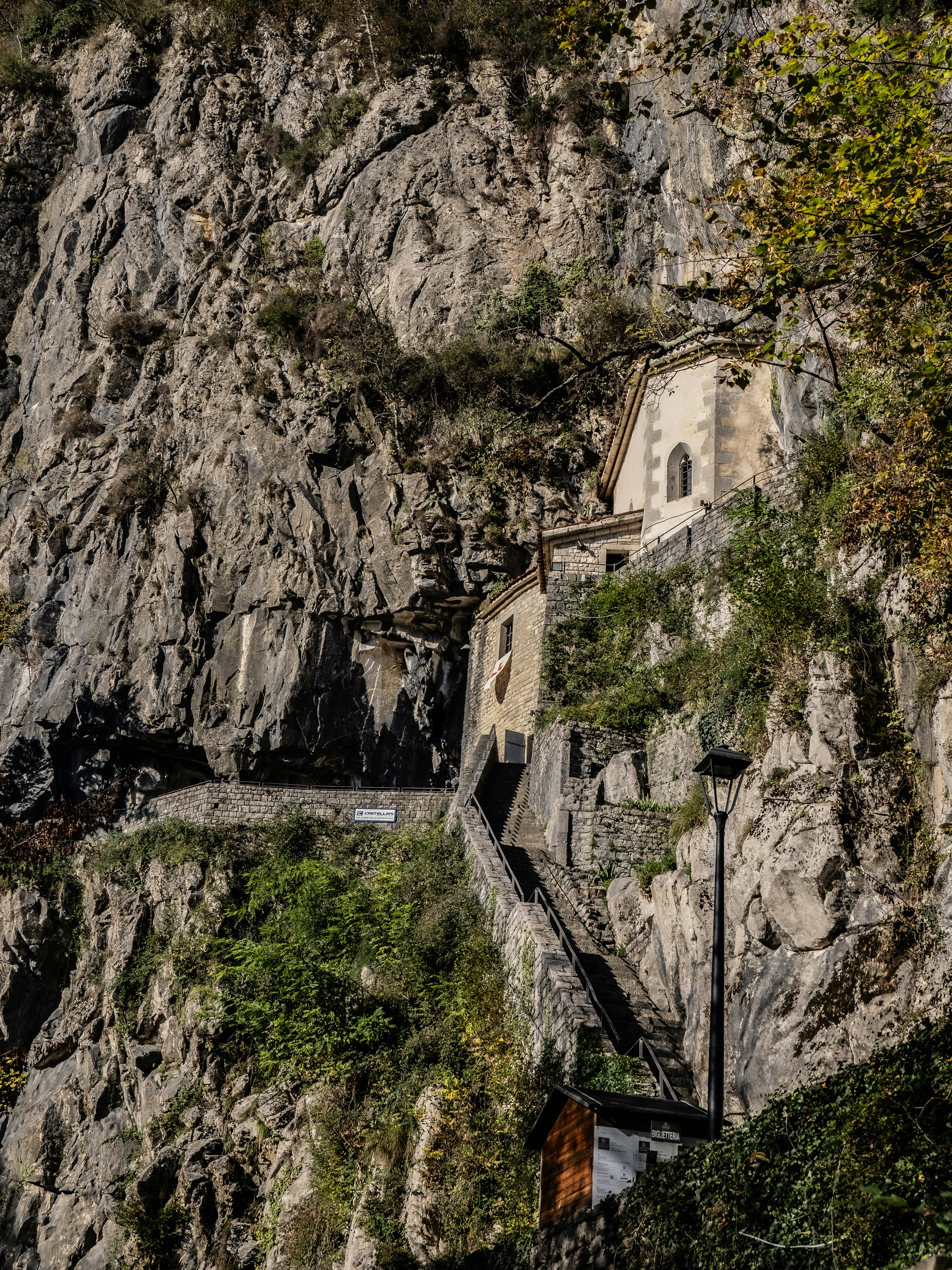 A small building built into a rocky cliff face. photo – Free Stone wall ...