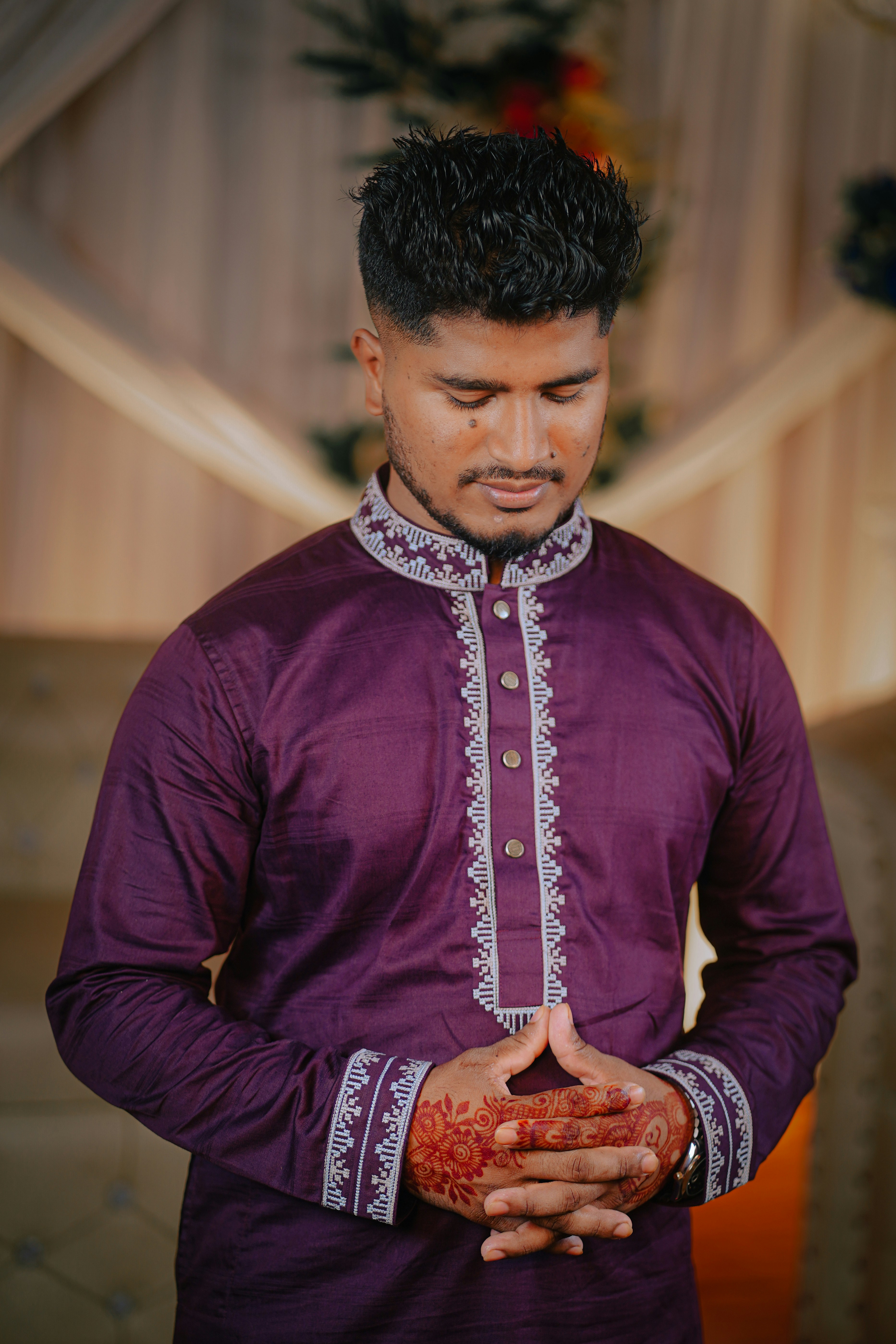 Quiet Reverie in Maroon: Hennaed Hands Folded Beneath Embroidered Threads