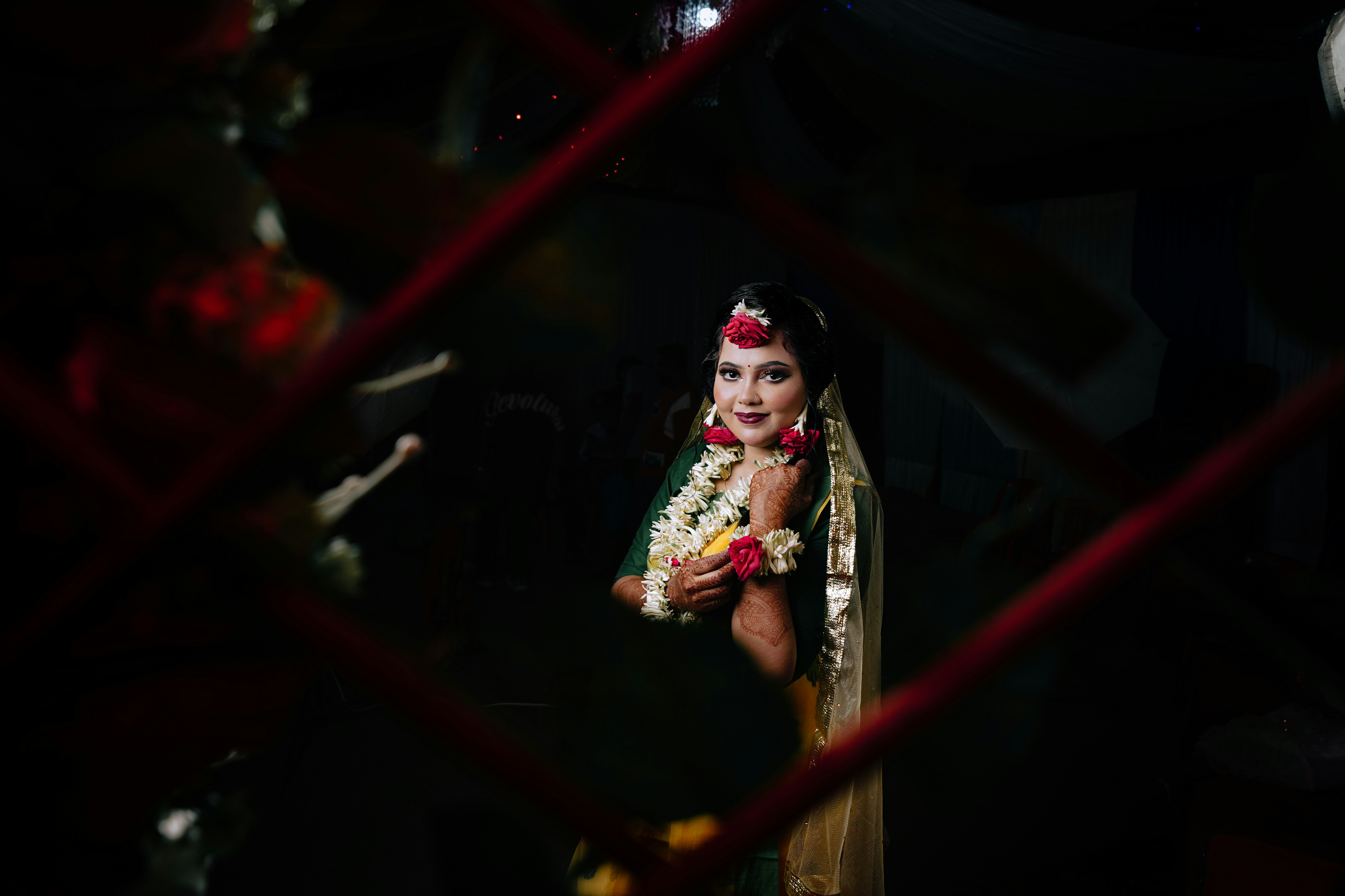 Crimson Framing, Golden Glow: Bride Lit on a Dark Stage