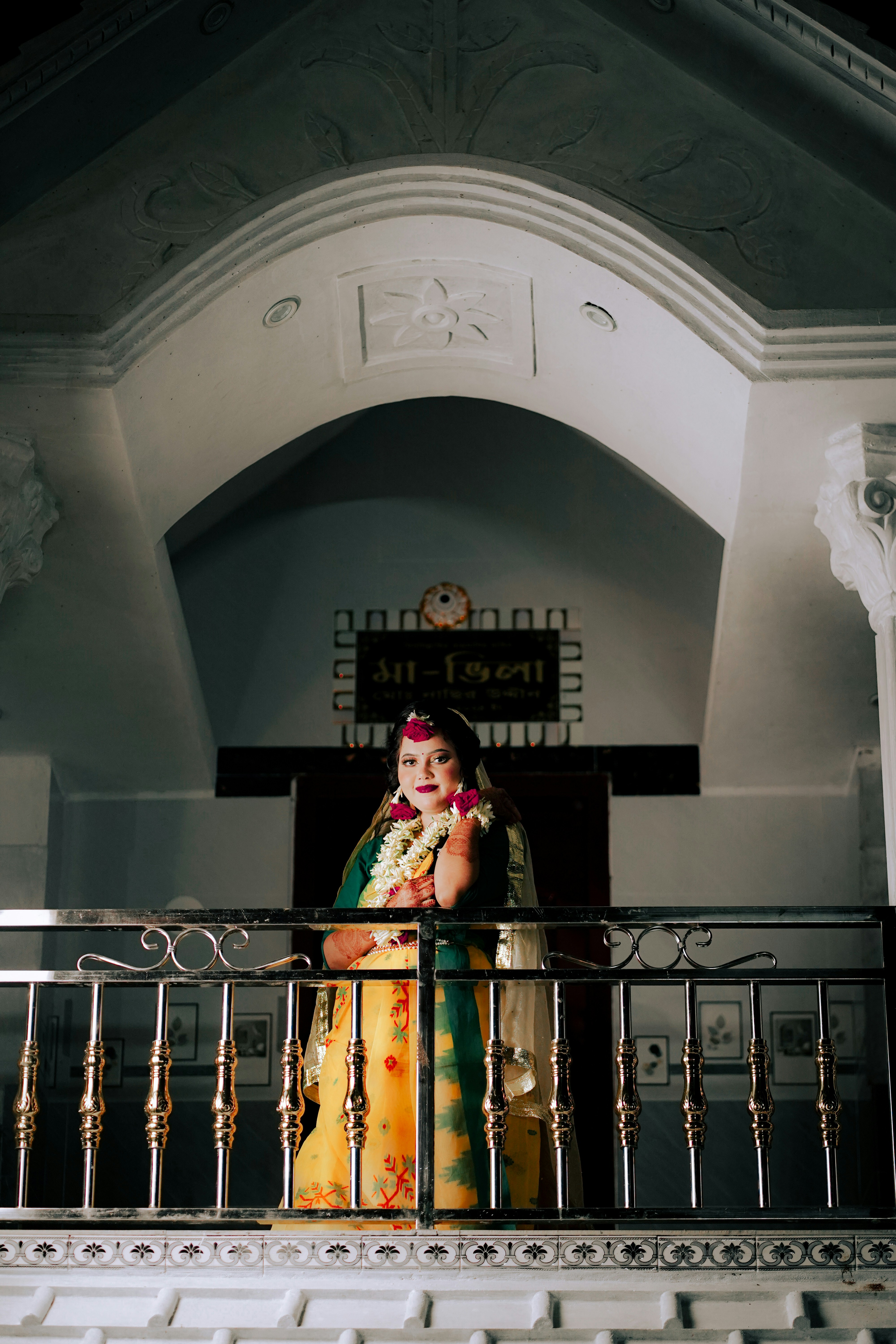 Balcony Bride: A Burst of Color Beneath an Ornate Arch