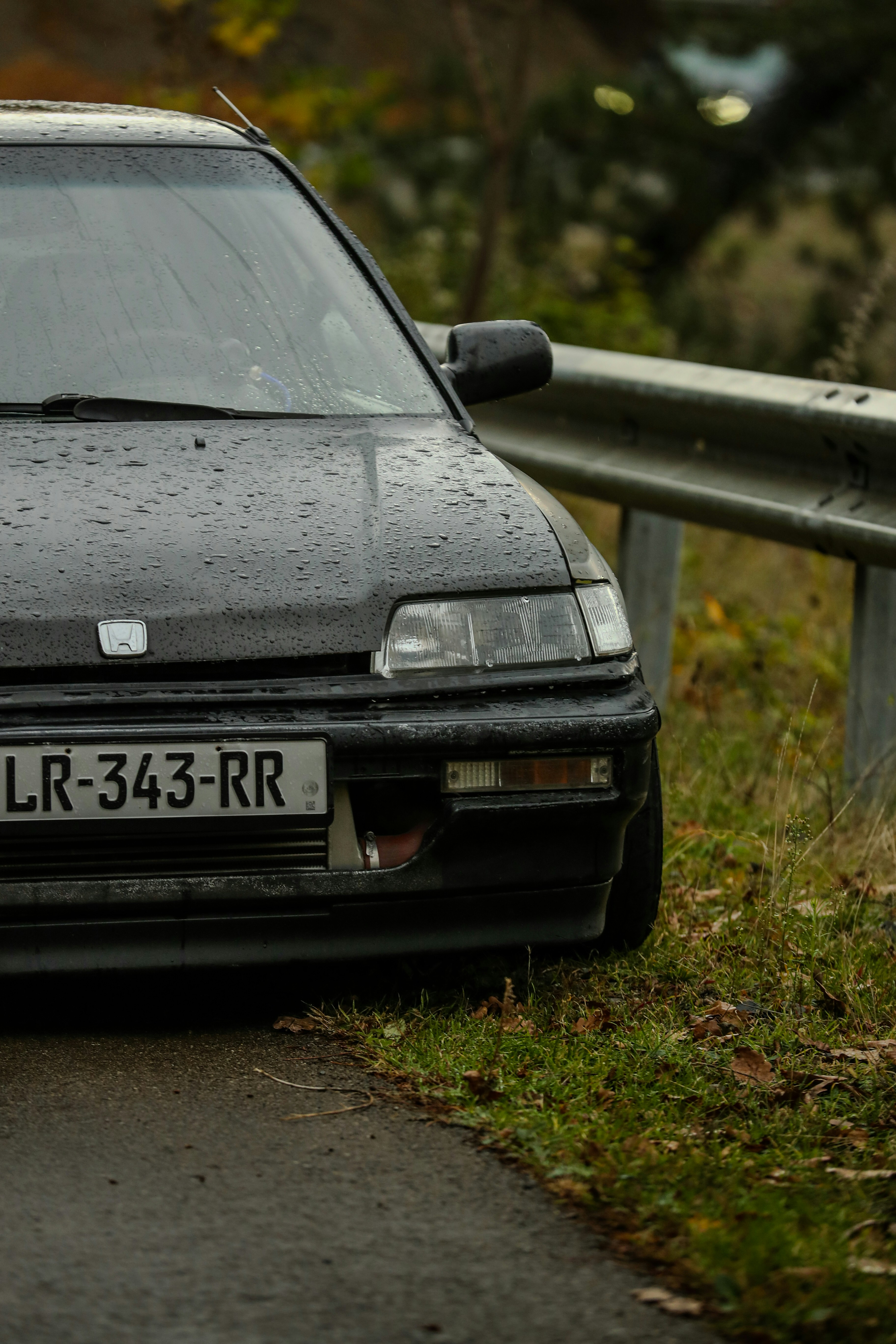 Weathered Nissan on the Verge: Raindrops and Roadside Quiet