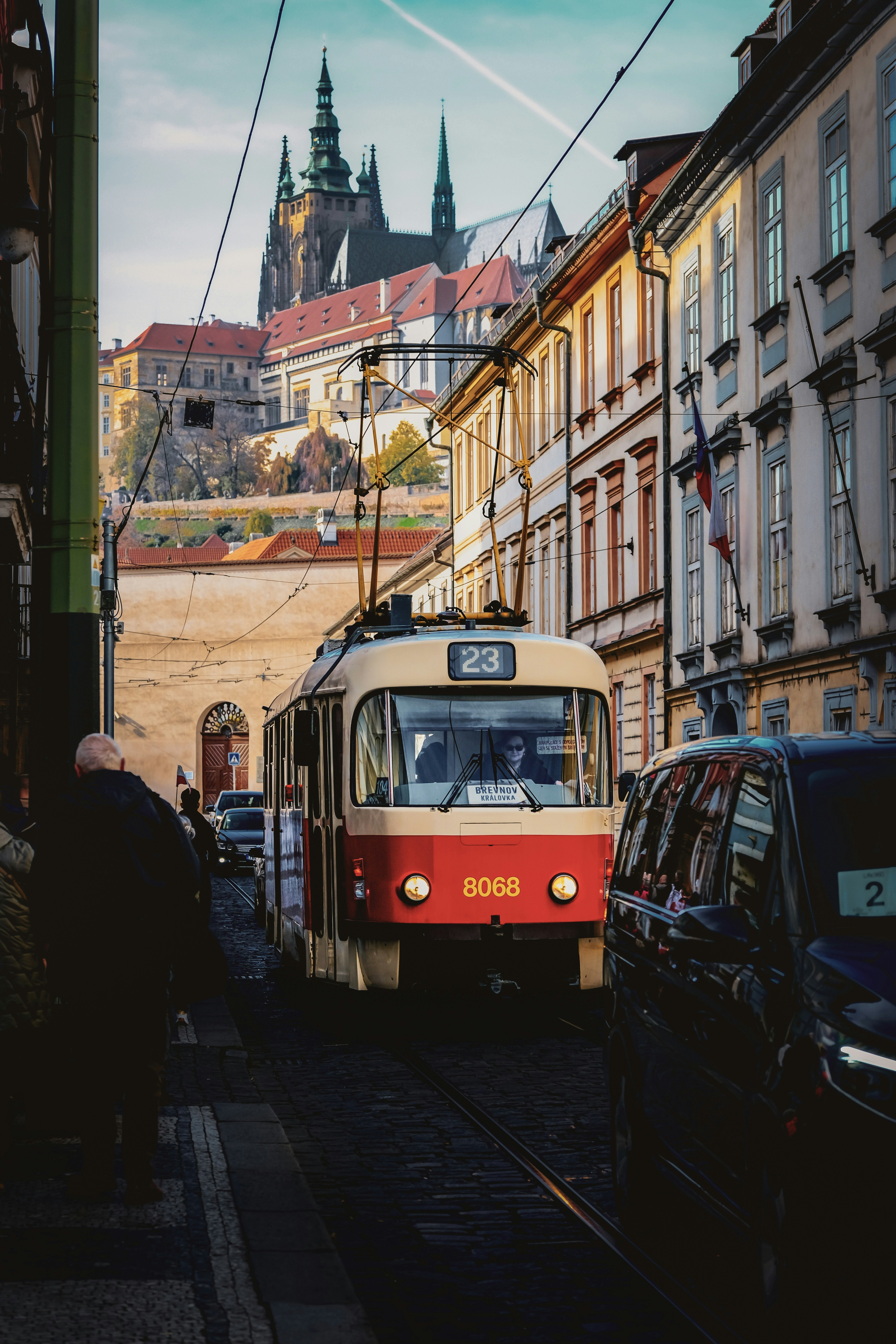 Crimson Streetcar Gliding Under Prague’s Spired Skyline