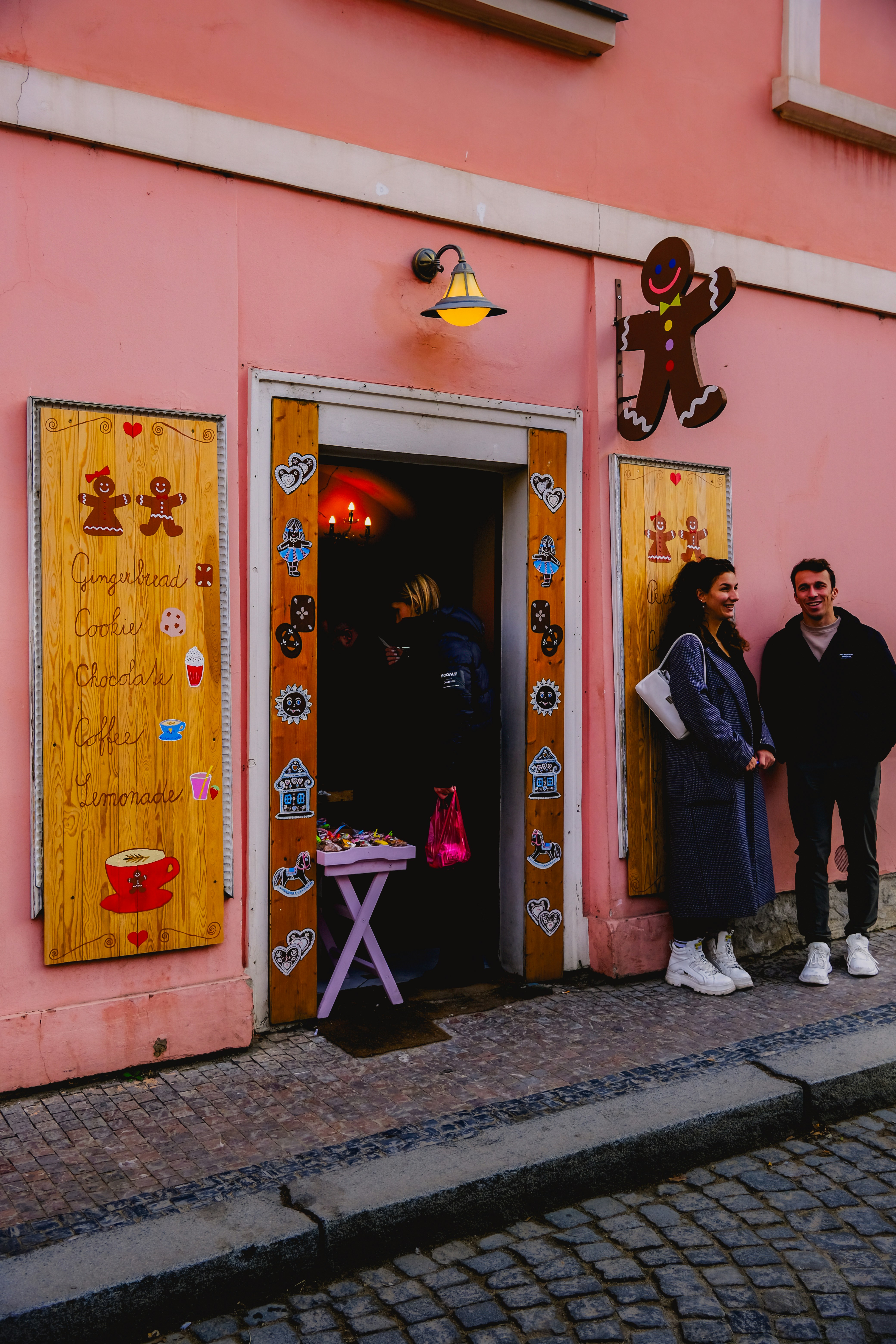 Pastel storefront doorway glowing with gingerbread decor
