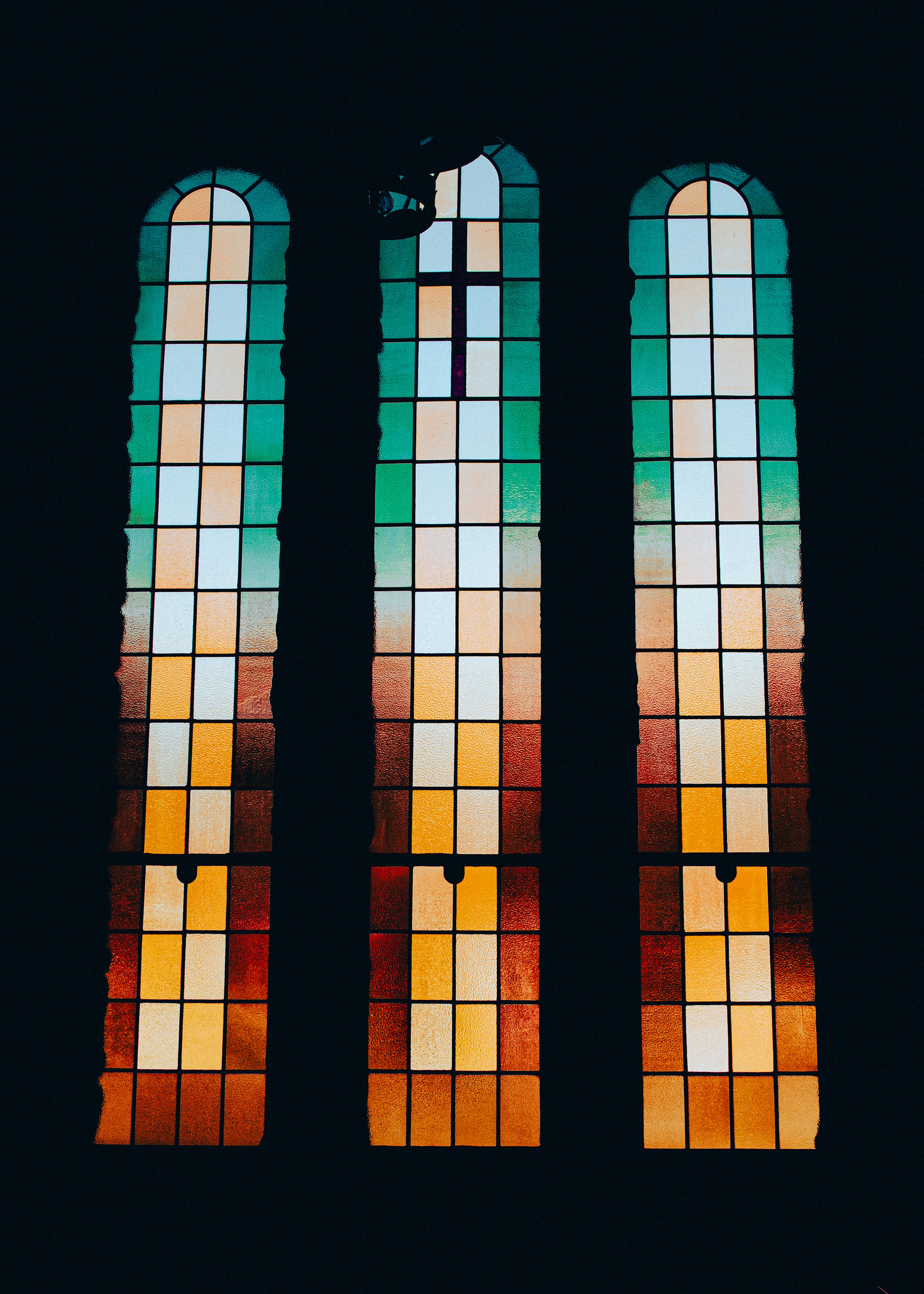 Three Arches, Three Hues: Stained-Glass Columns in a Dark Nave