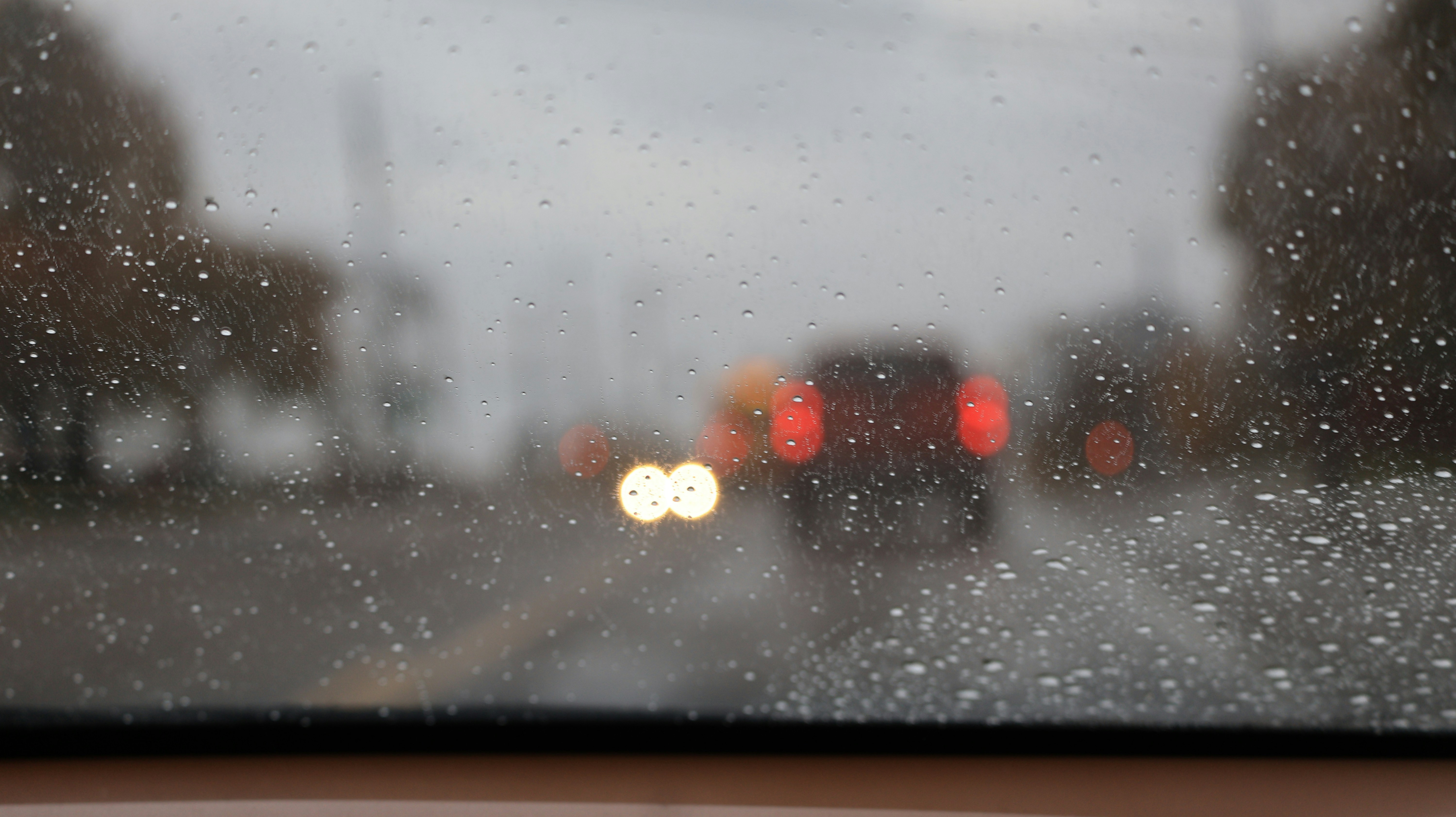 Rain-Blurred Commute: Red Tail Lights through a Glass Screen