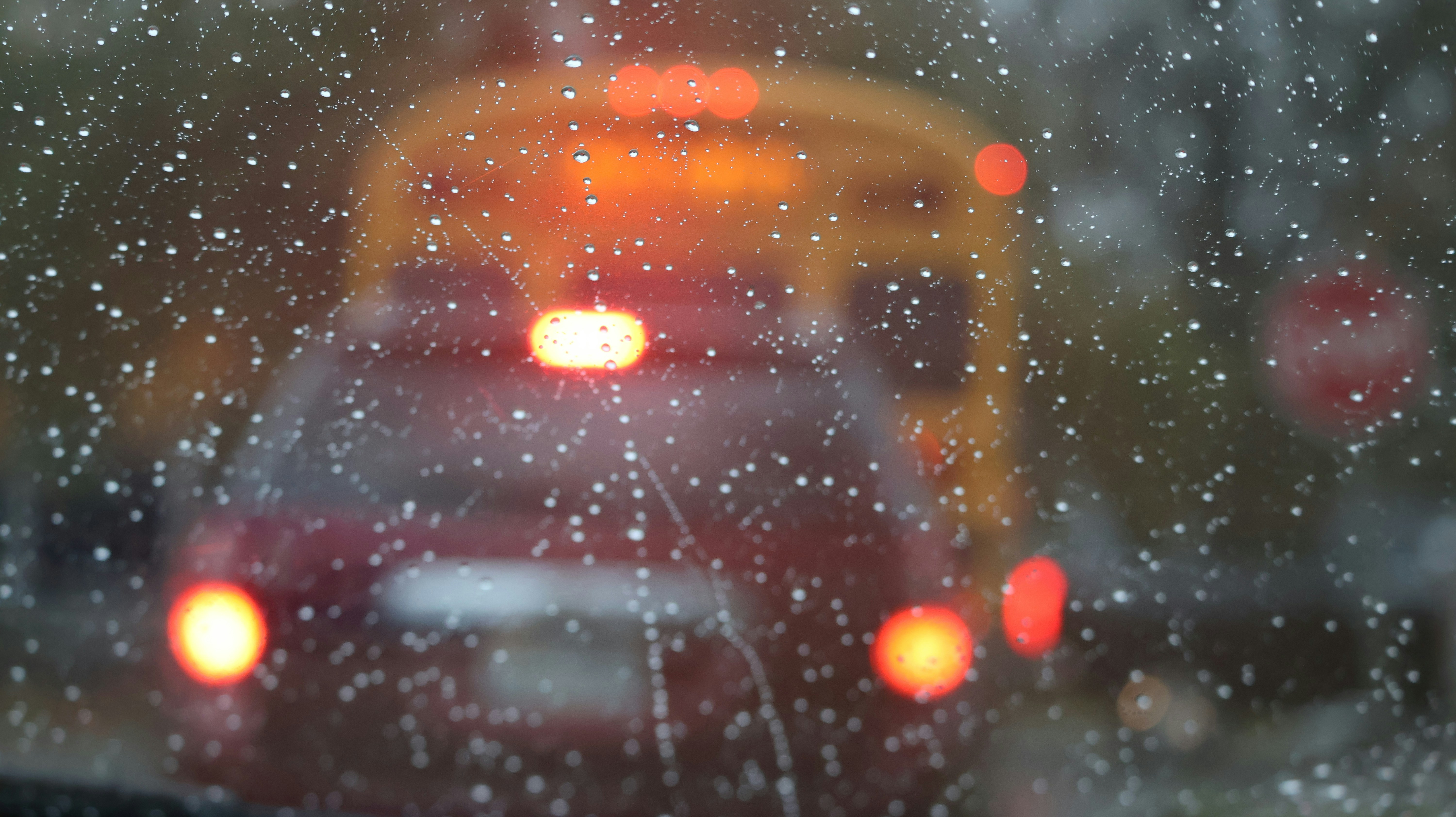 Red Taillights Through Rain-Splashed Glass: Blur and Quiet Motion in City Traffic