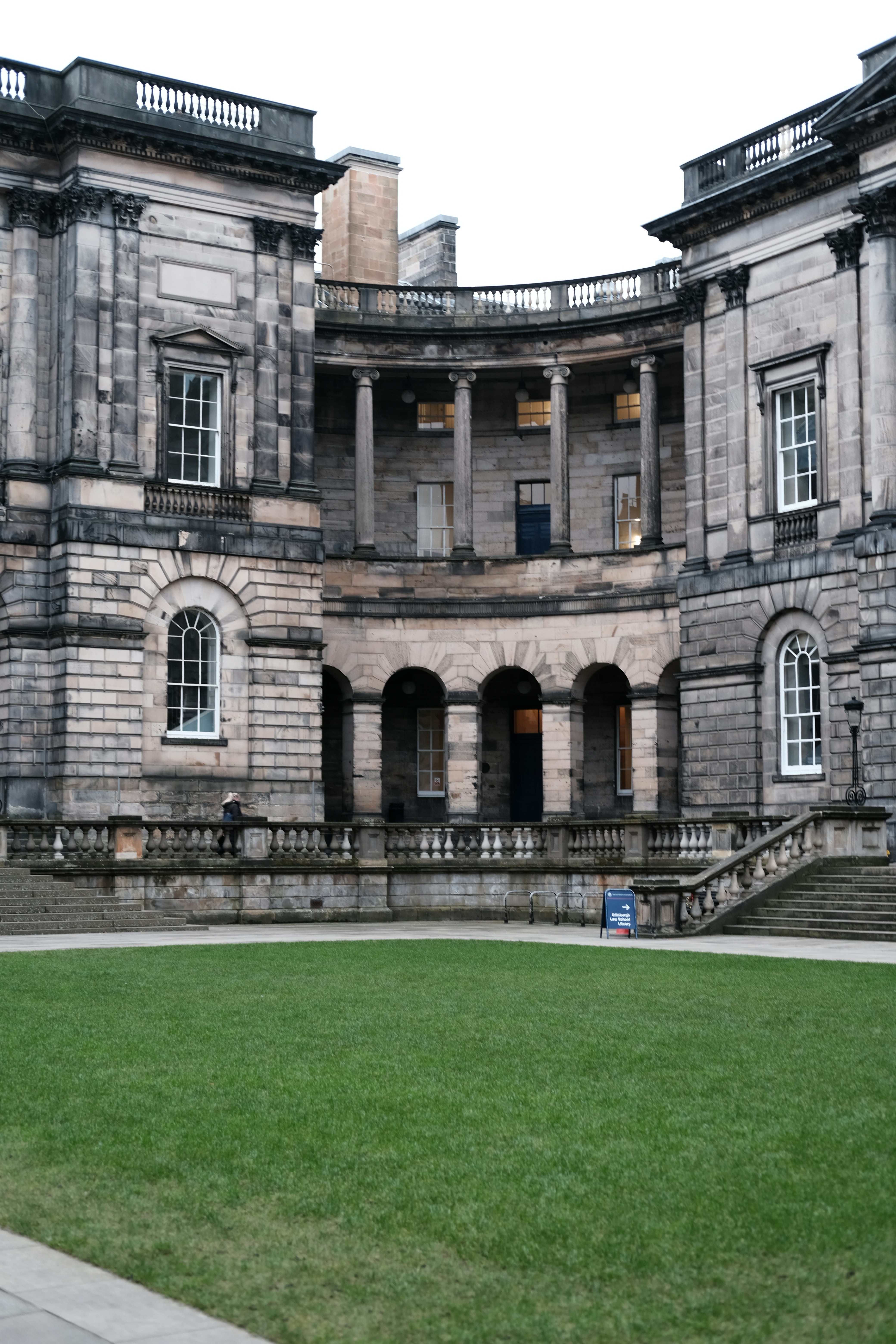 Arched Grandeur: A Curved Facade Framed by Lawn