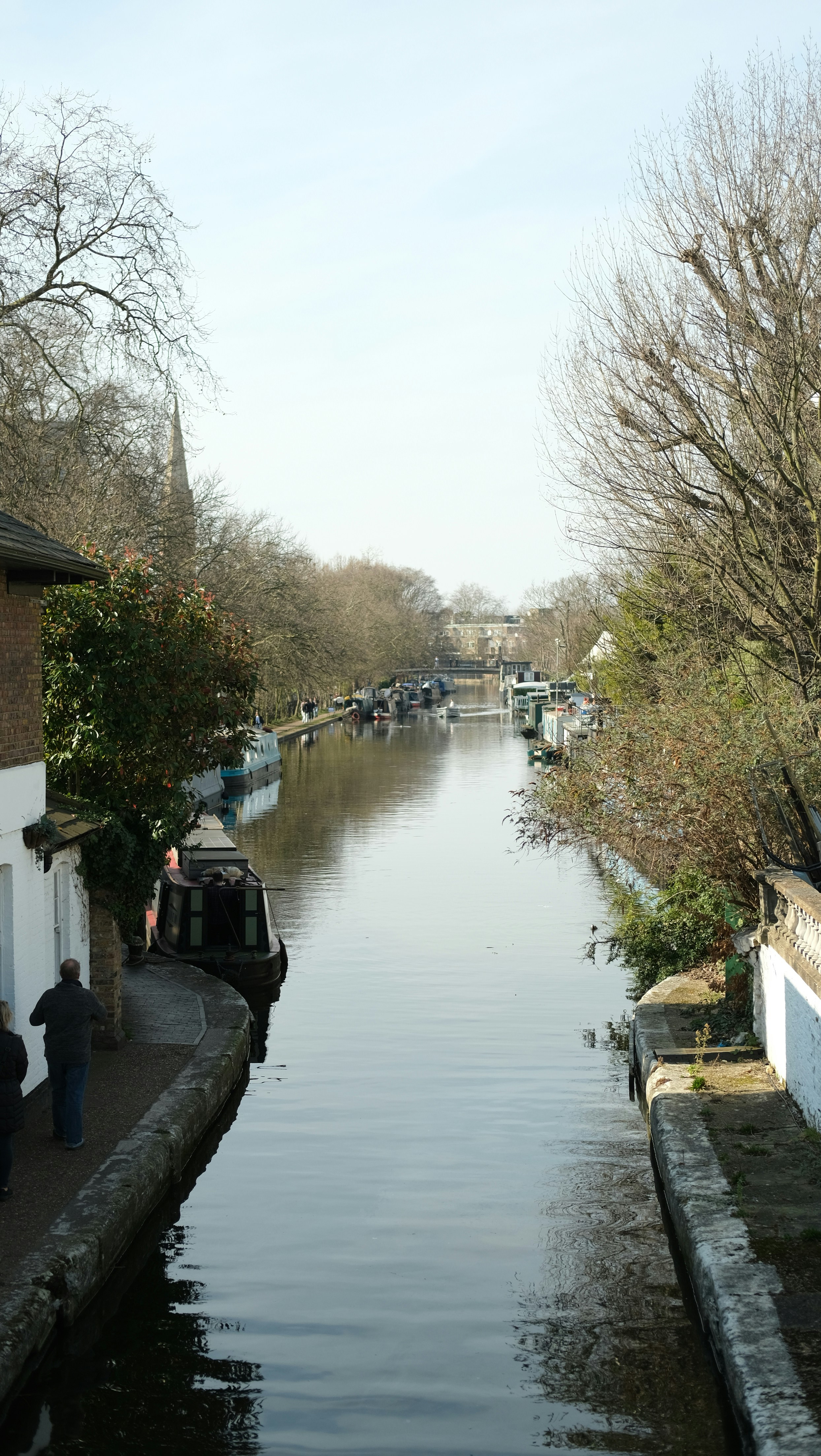 Morning Quiet on a Narrow Canal: Reflections, Boats, and Leaf-Lined Banks