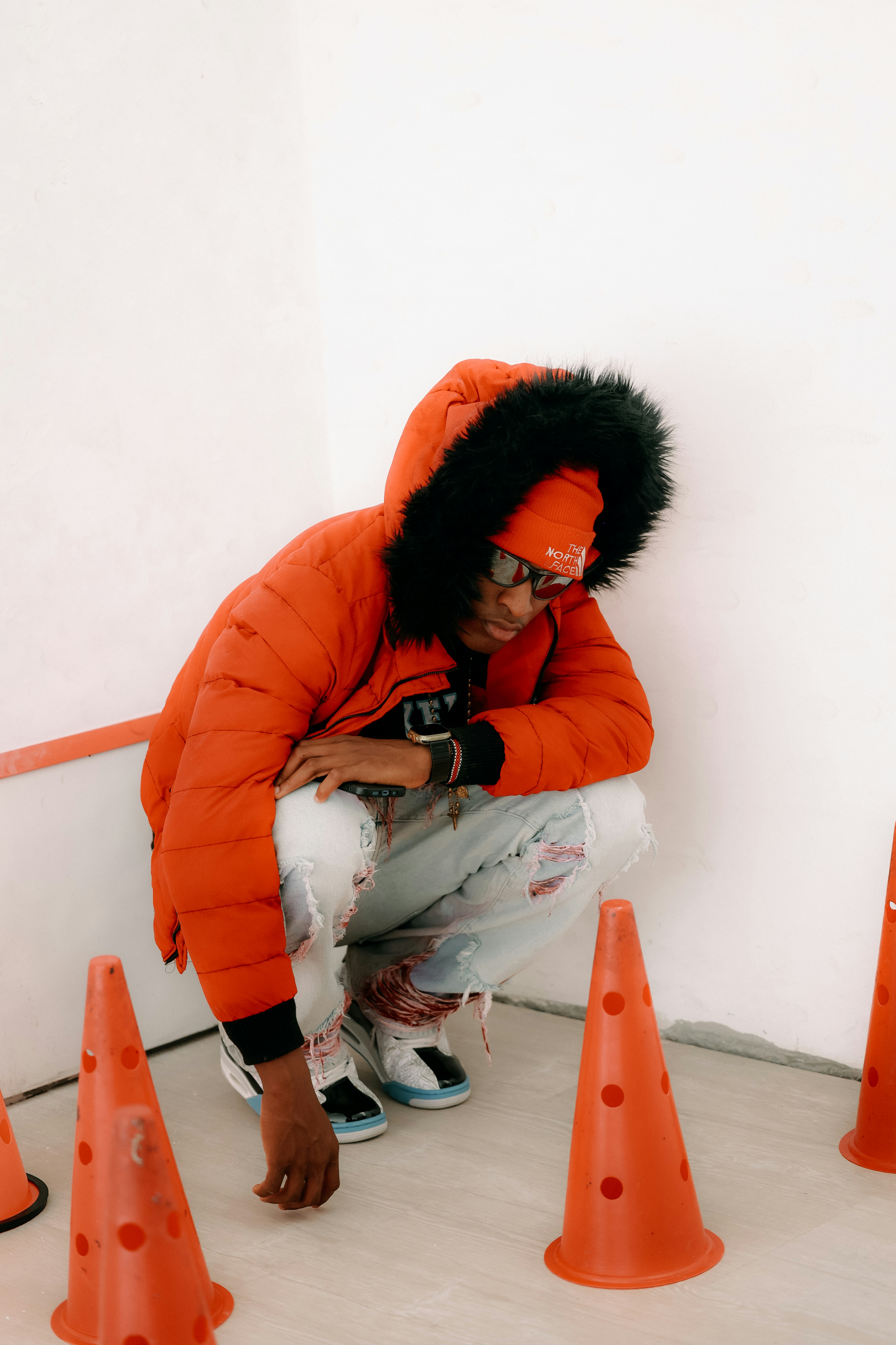 Crimson Parka in a Corner of Safety Cones