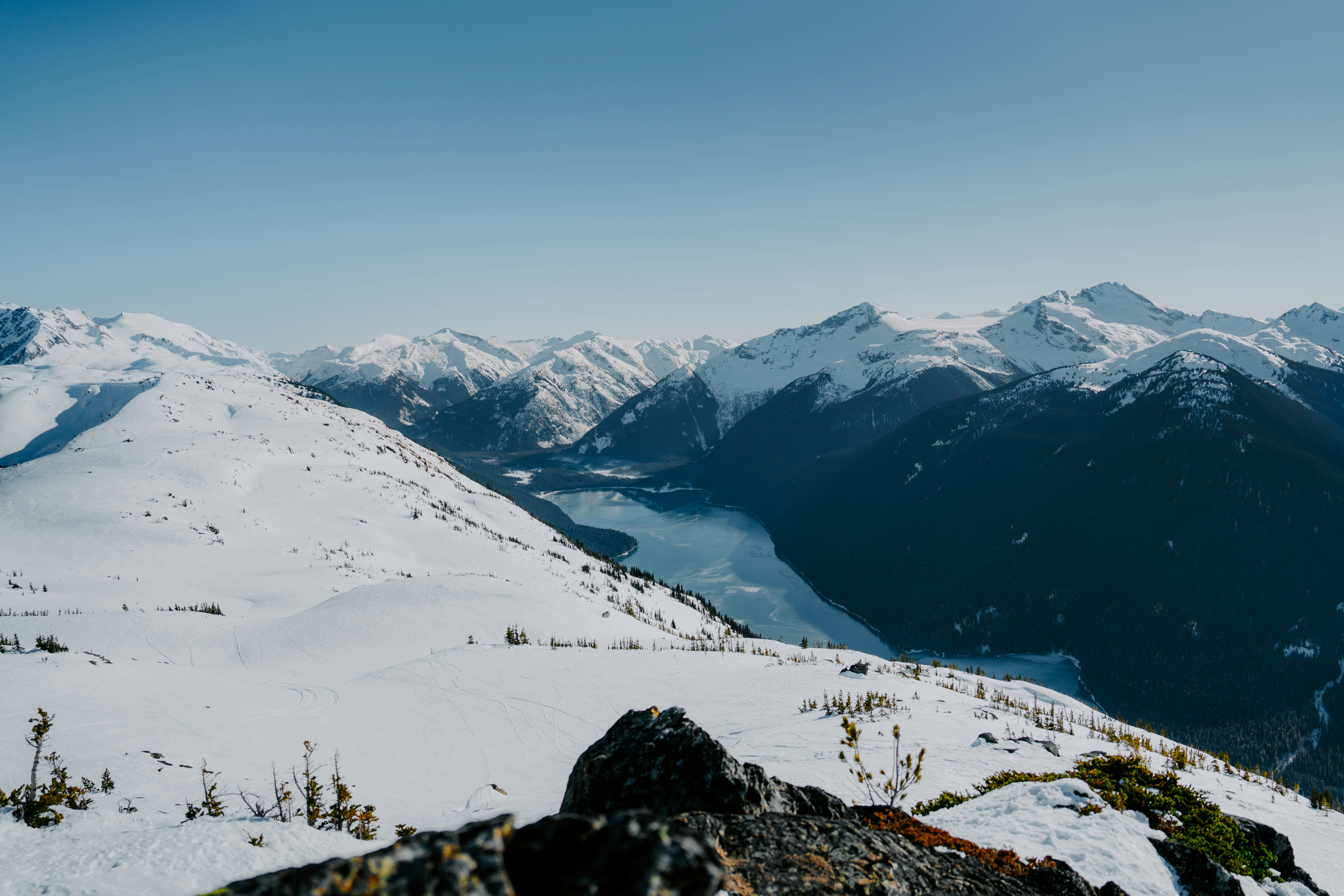 Snow-covered mountains surround a calm blue lake. photo – Free Mountain ...