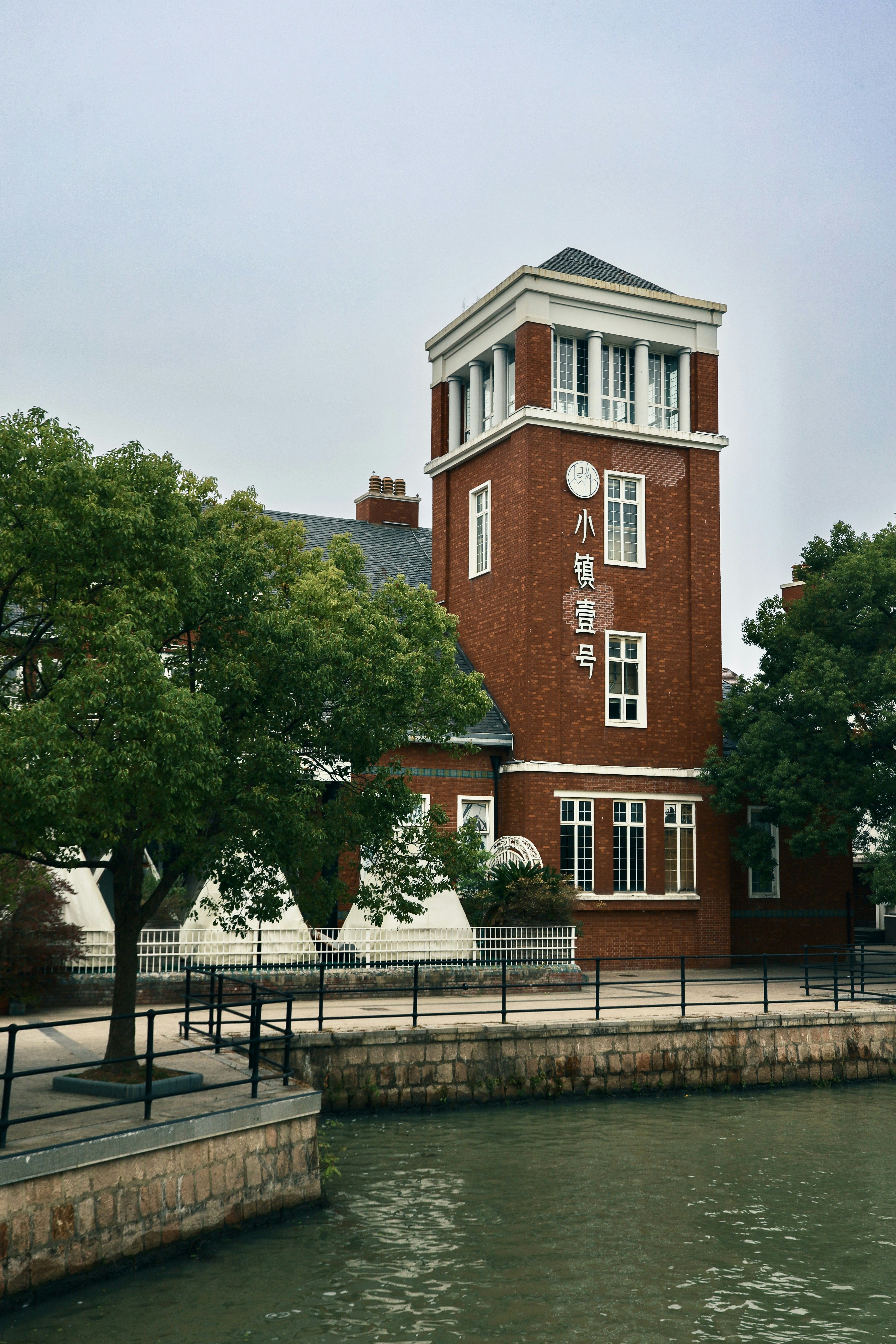 Red-Brick Clock Tower Watching Over a Quiet Riverside Canal