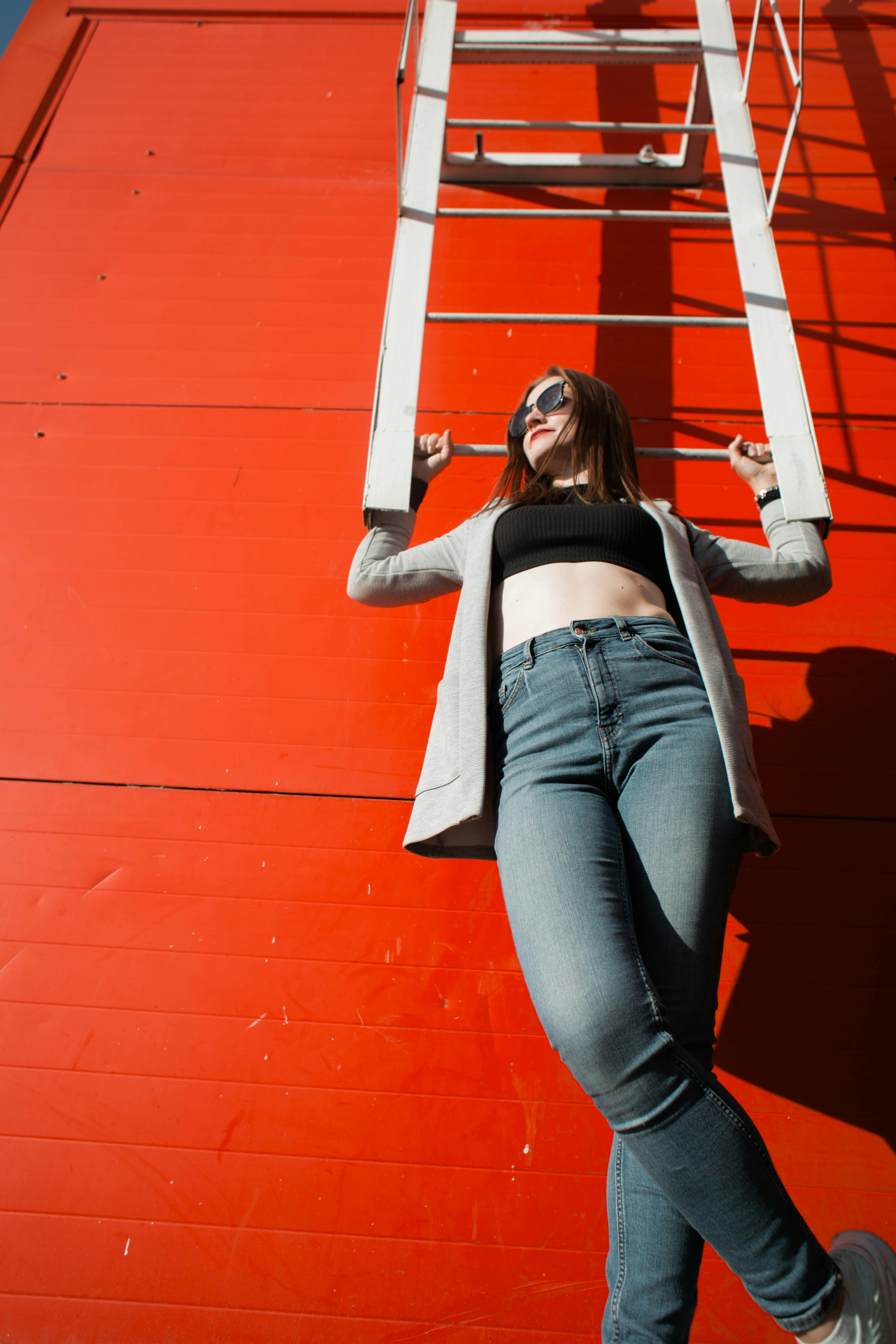 Crimson Wall Portrait: A Lean Against the Ladder Under the Sun