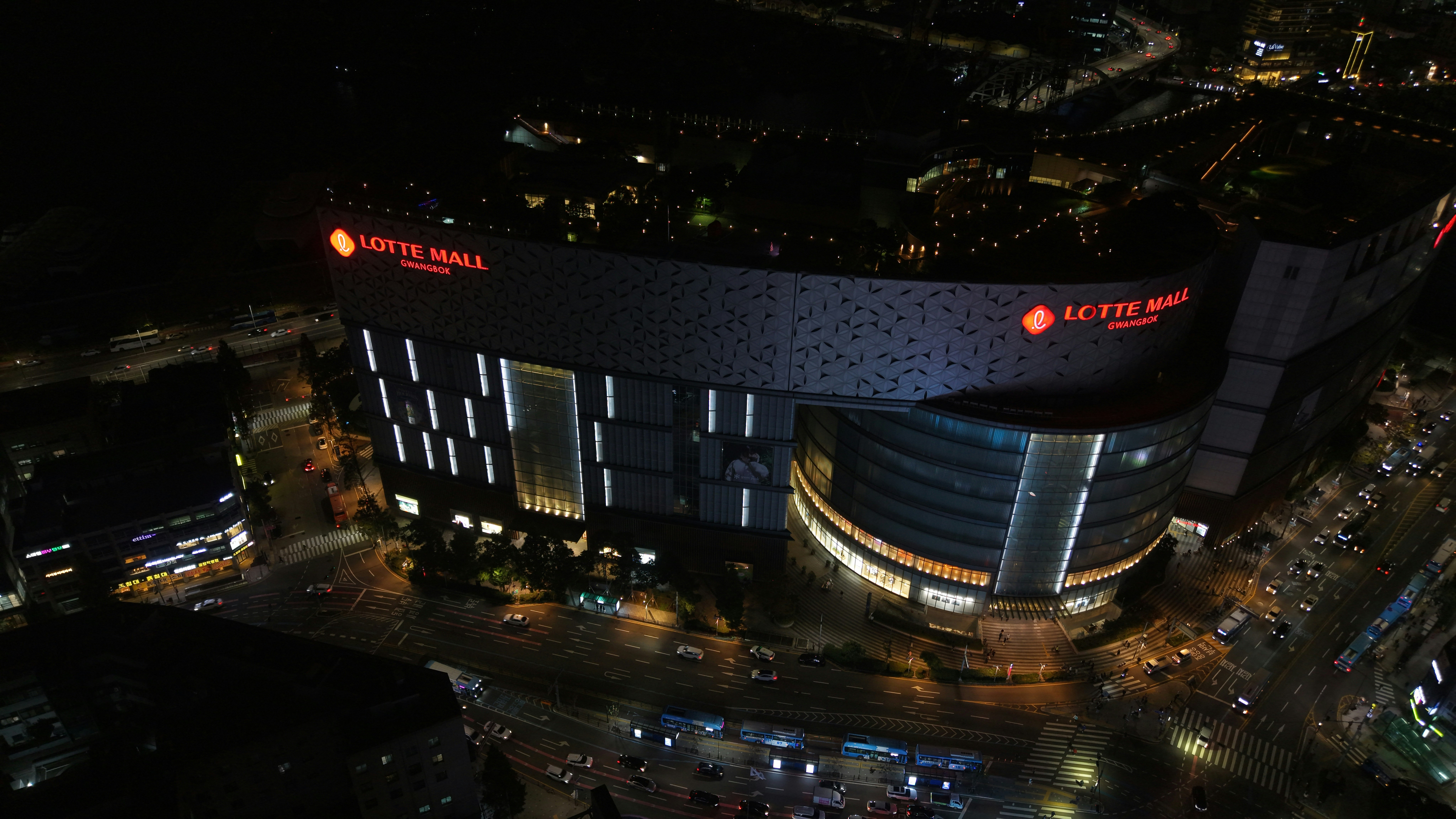 Neon Spine Over Lotte Mall: Aerial Night View of Downtown