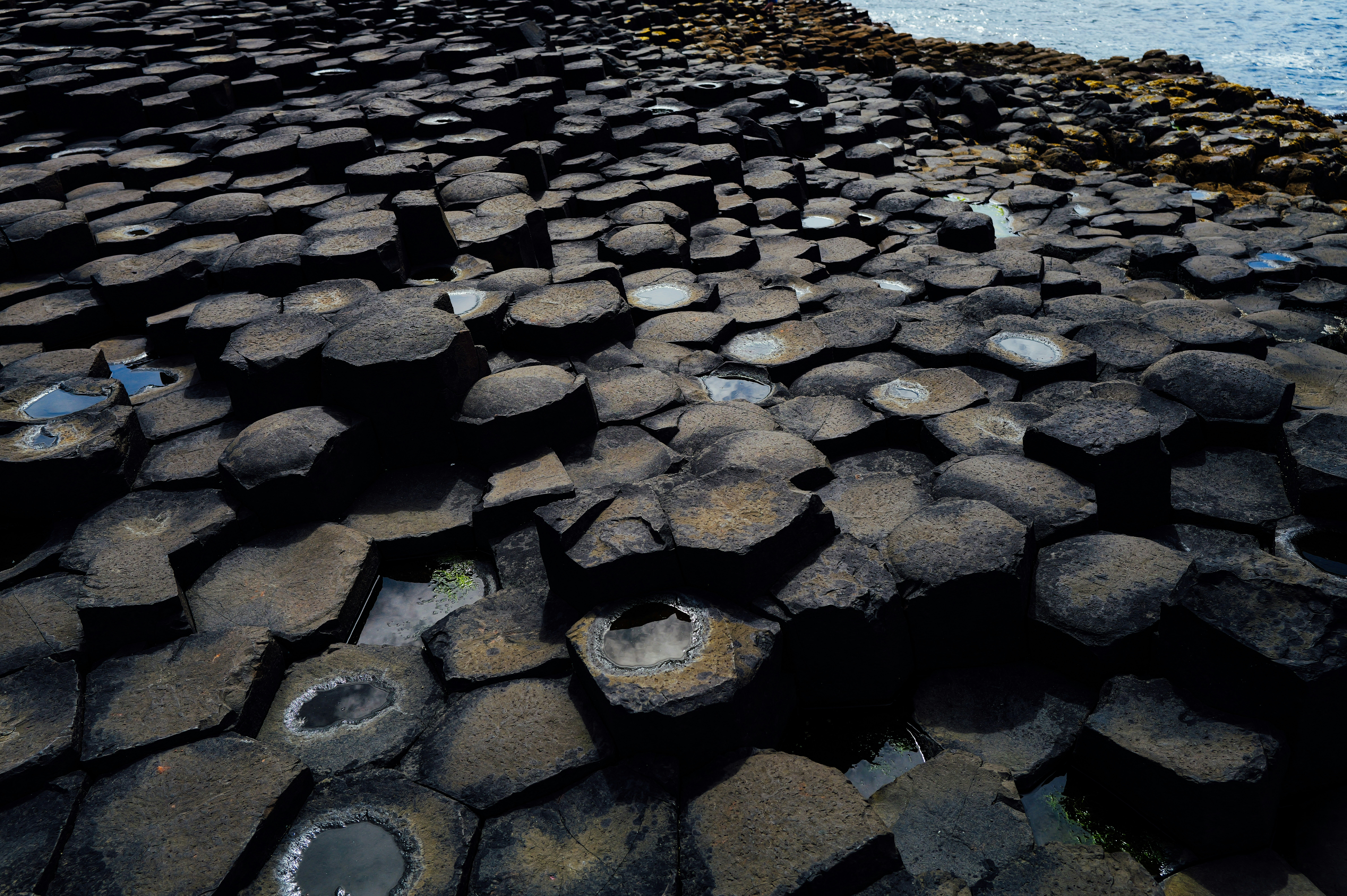 Hexagonal basalt columns on a rocky coastline photo – Free Stone Image ...