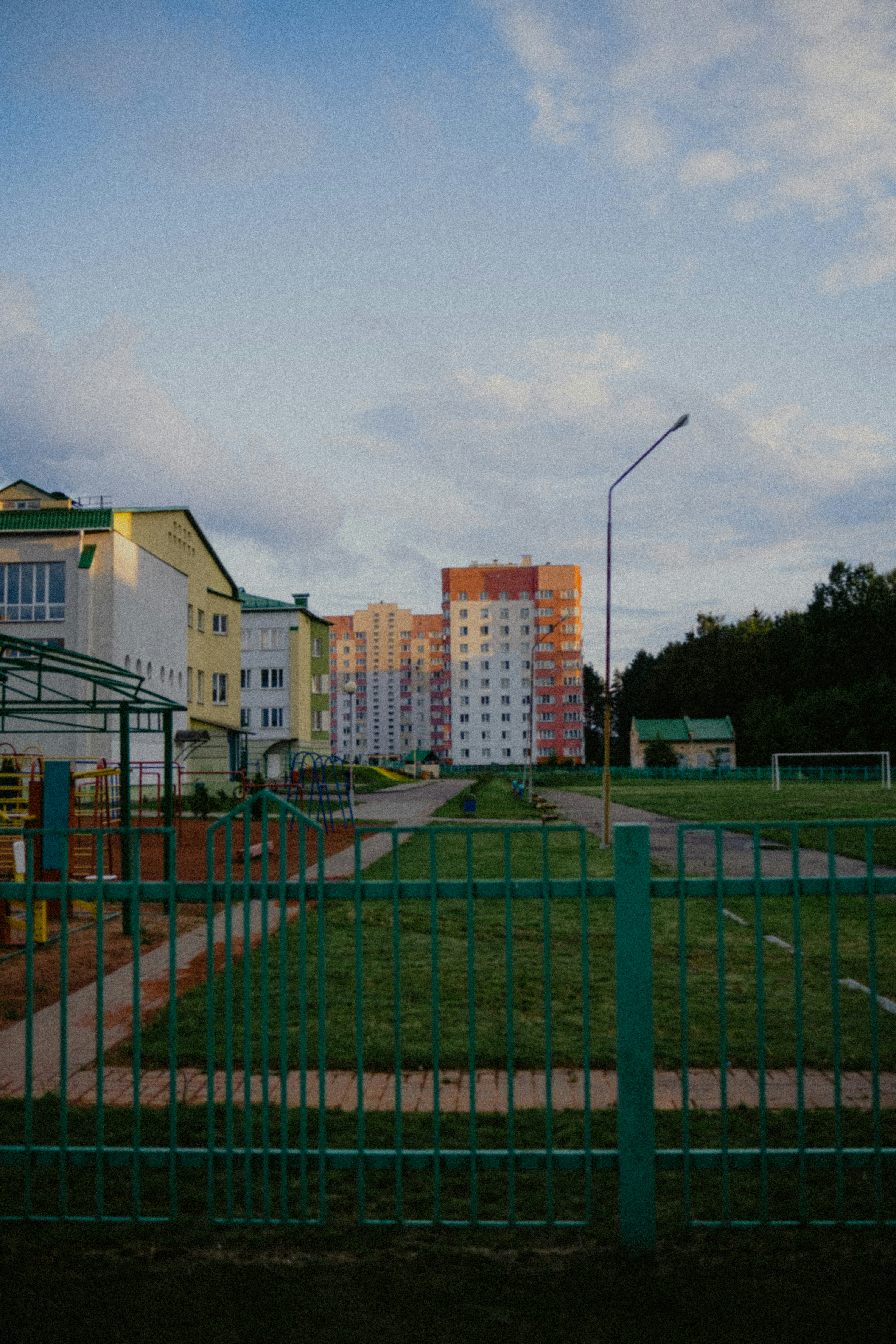 Pastel Towers Framed by a Teal Fence