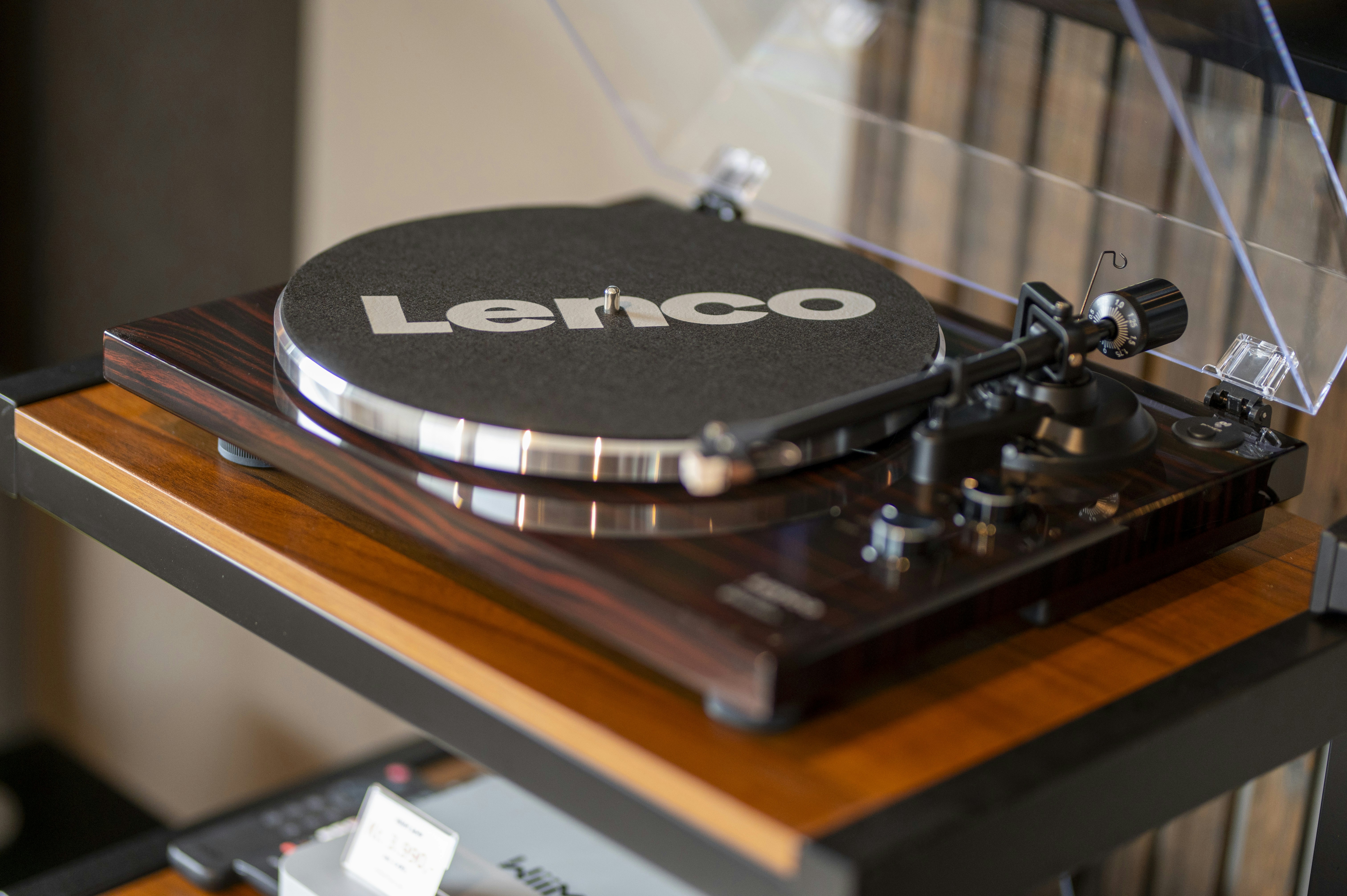 Leinko on Walnut: Close-Up of an Analog Turntable Under Glass