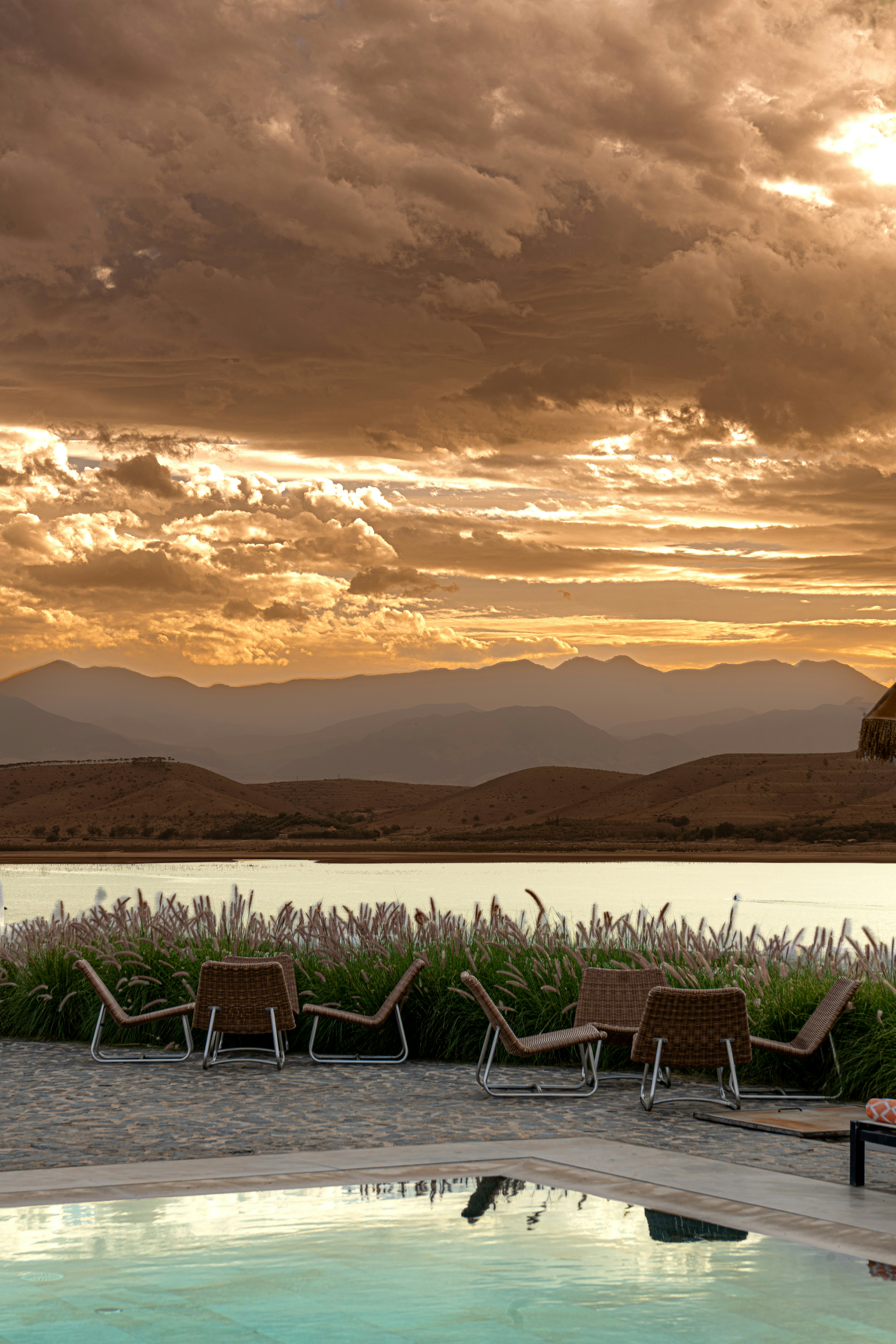 Poolside Reverie: Wicker Chairs Framing a Desert Sunset