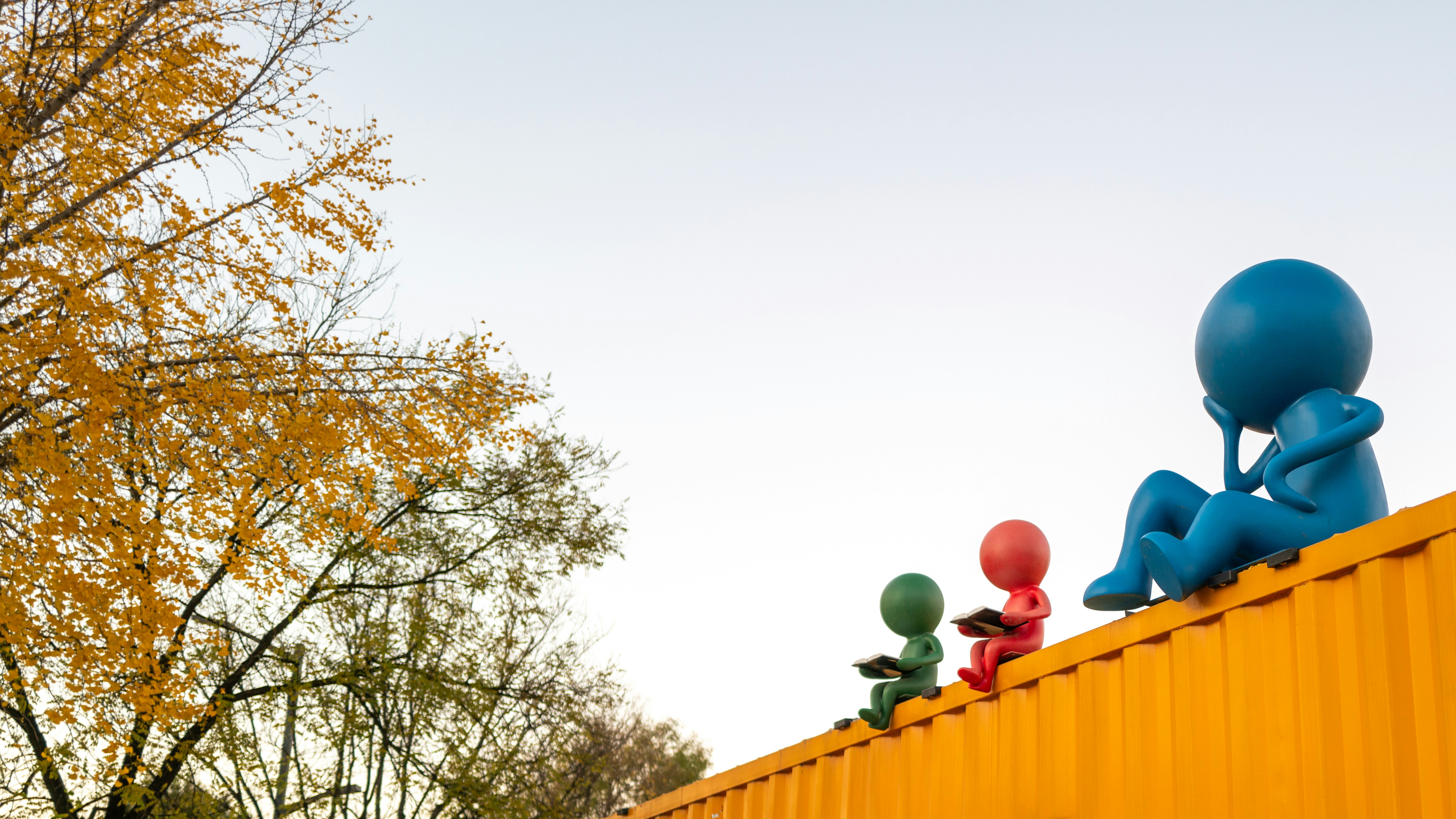 Blue Sentinel Over a Sunlit Slide: A Tiny Parade in Autumn
