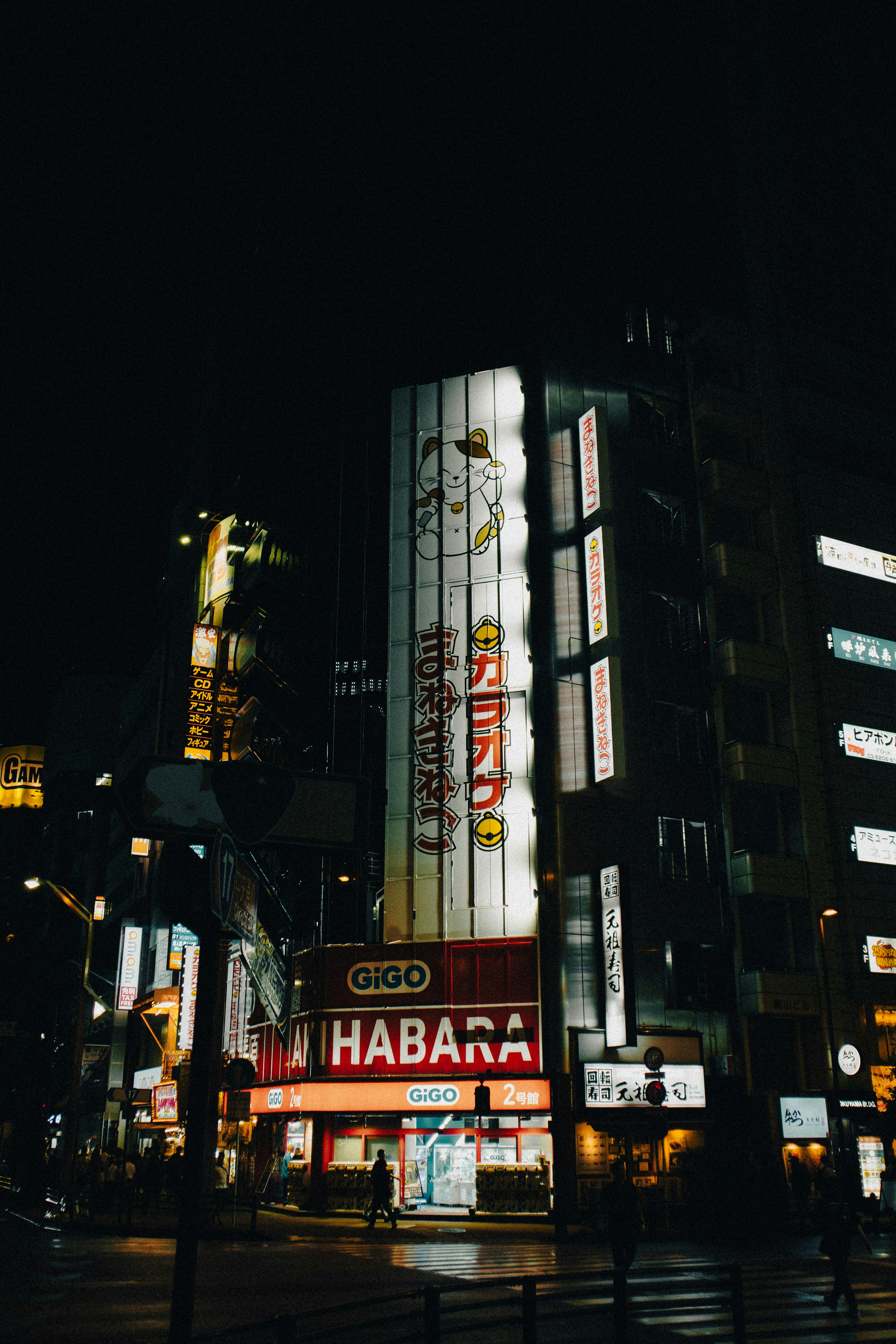 Neon Manga Tower Illuminates a Quiet Night Street
