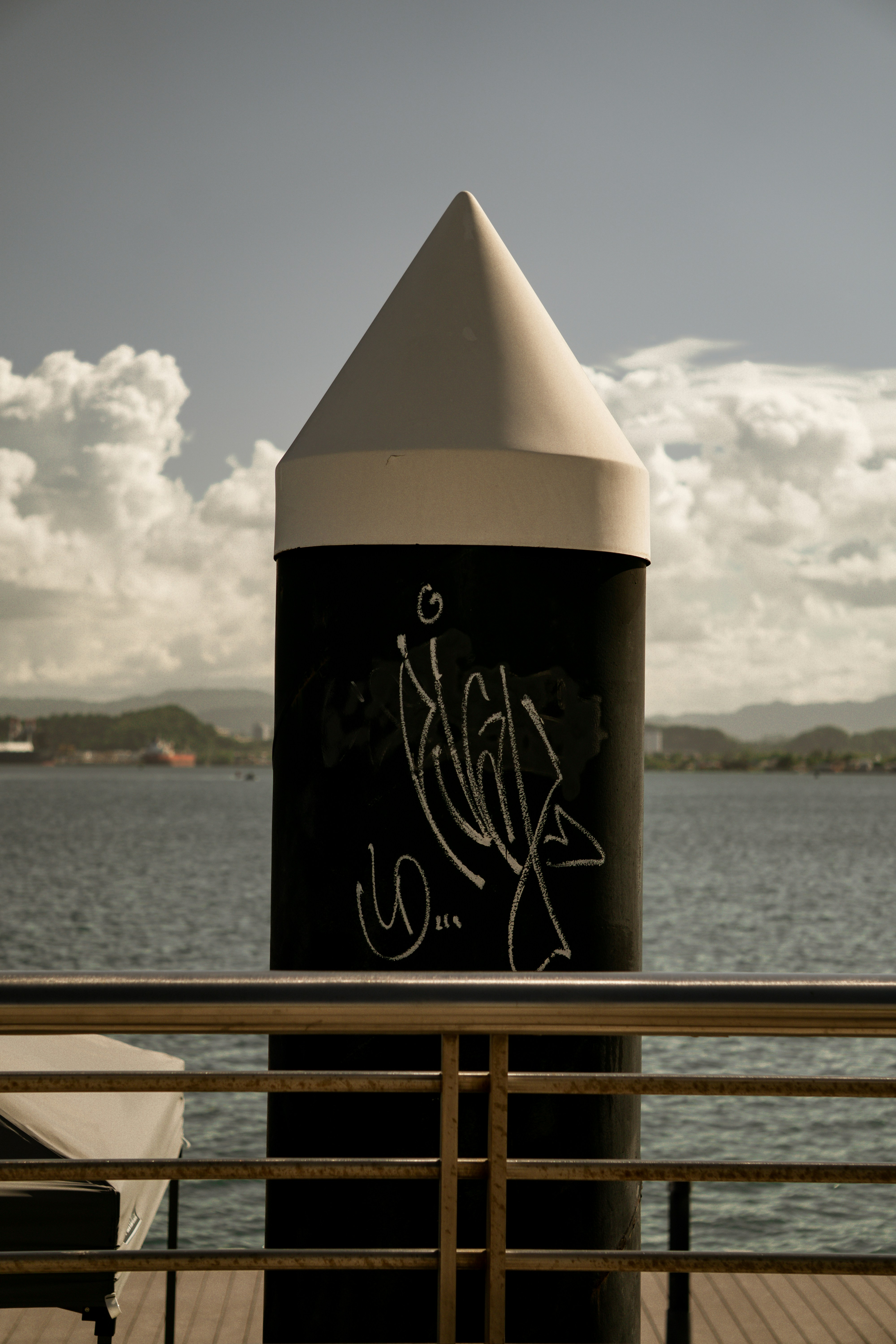 Cone-Topped Bollard: Graffiti Meets Waterfront Geometry