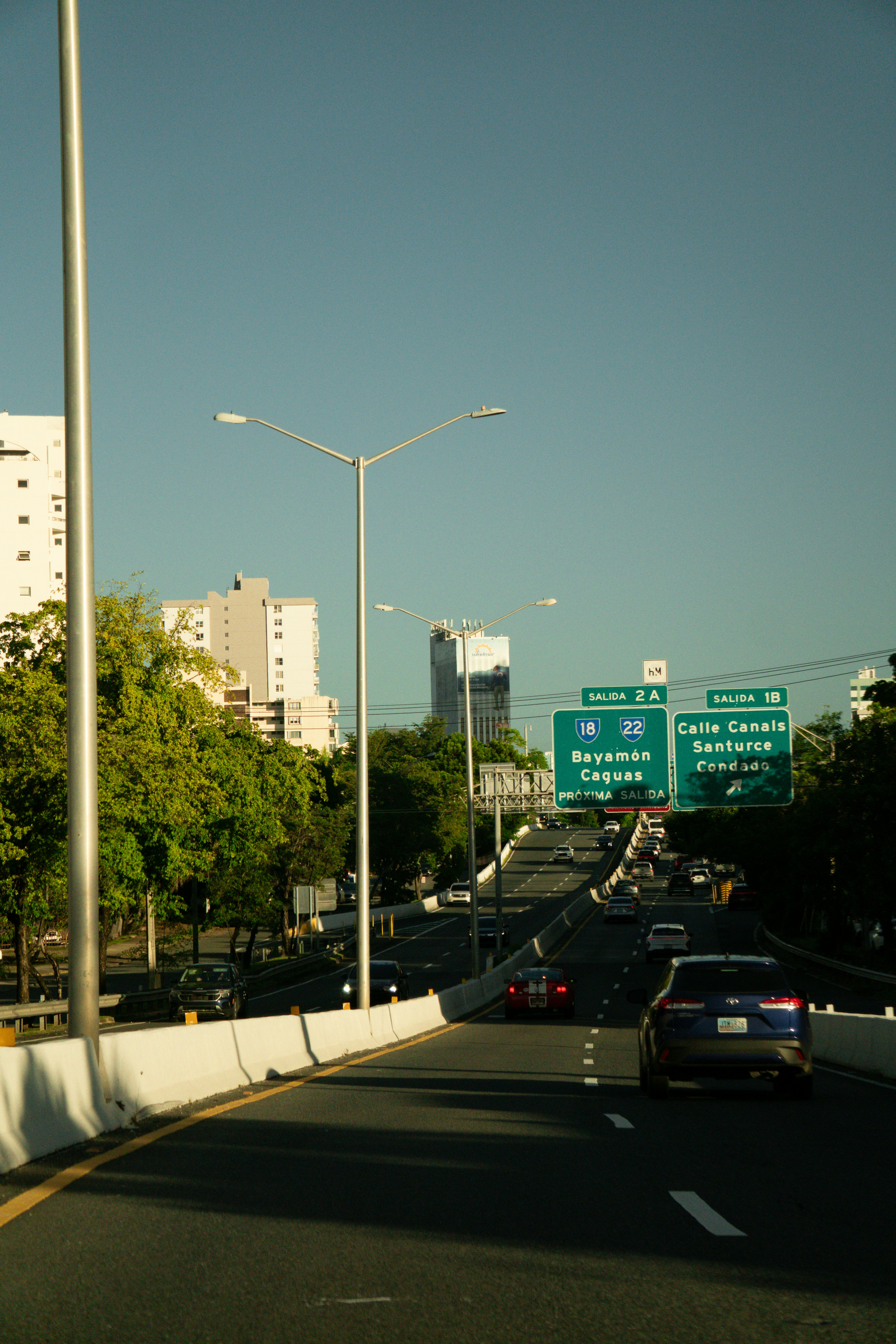 Dawn on the Expressway: Green Overhead Signs Span a City-Bound Corridor