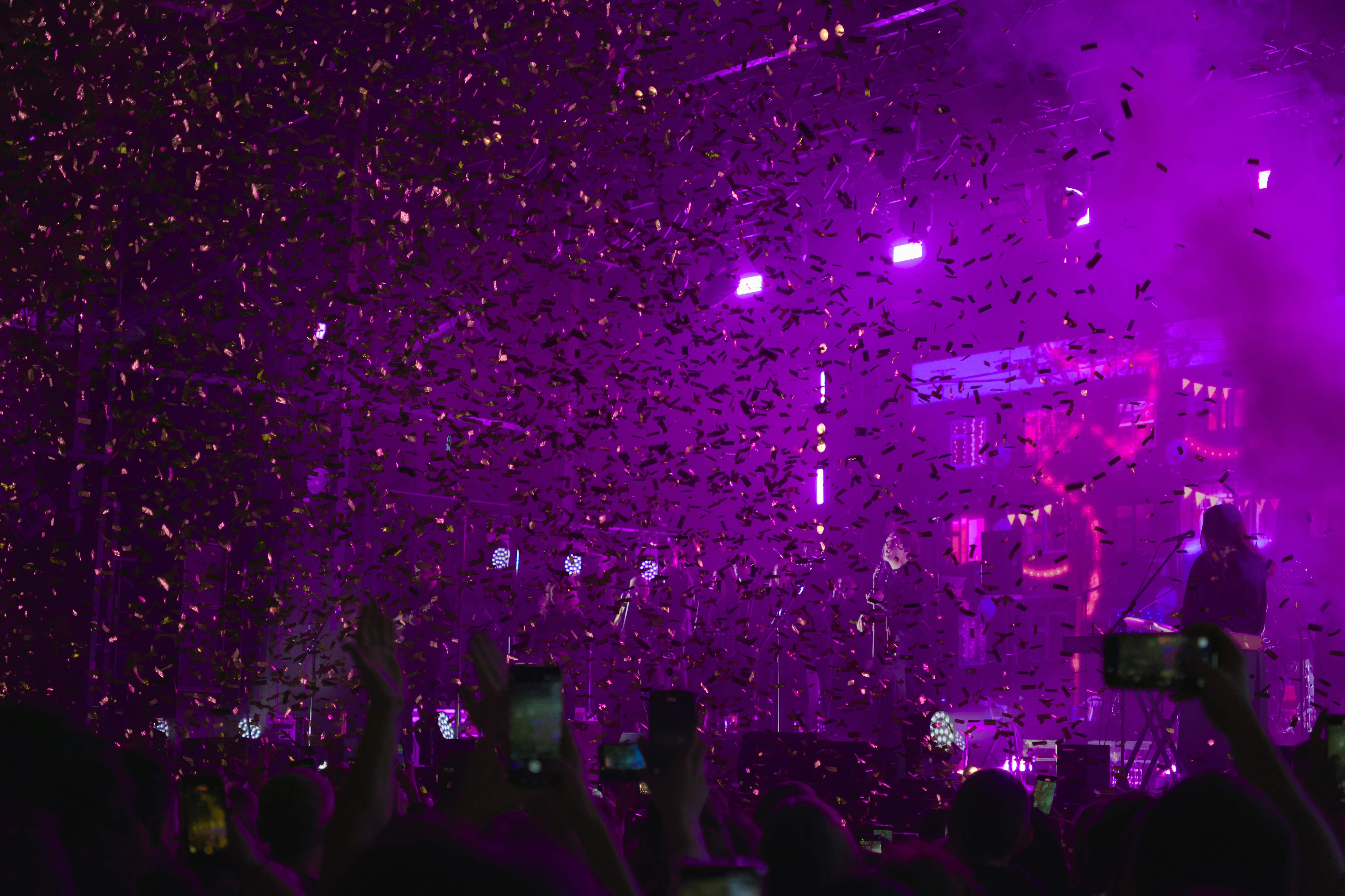 Confetti Cascade Over Neon Purple Concert Stage