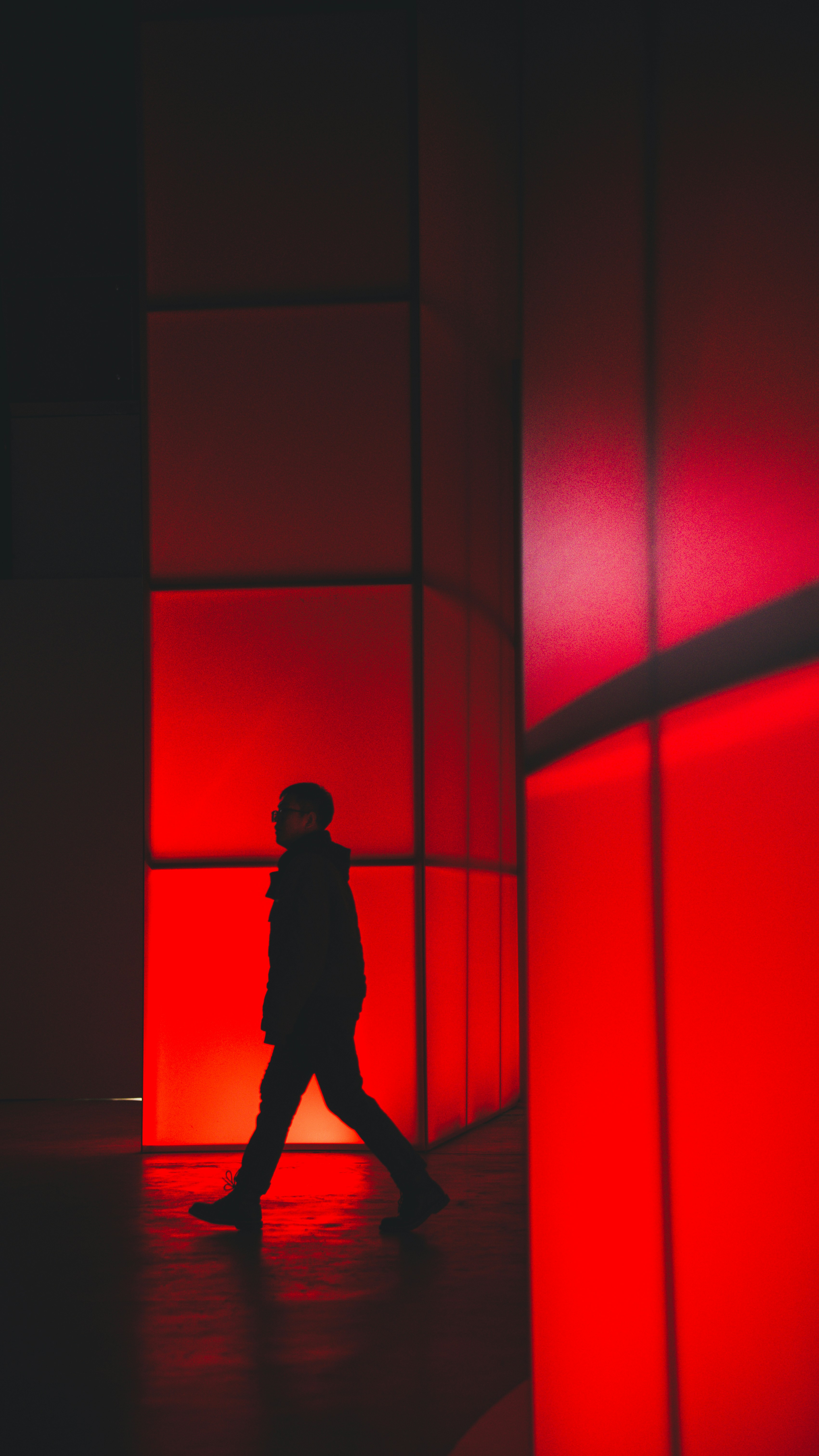 The man walking past the red background