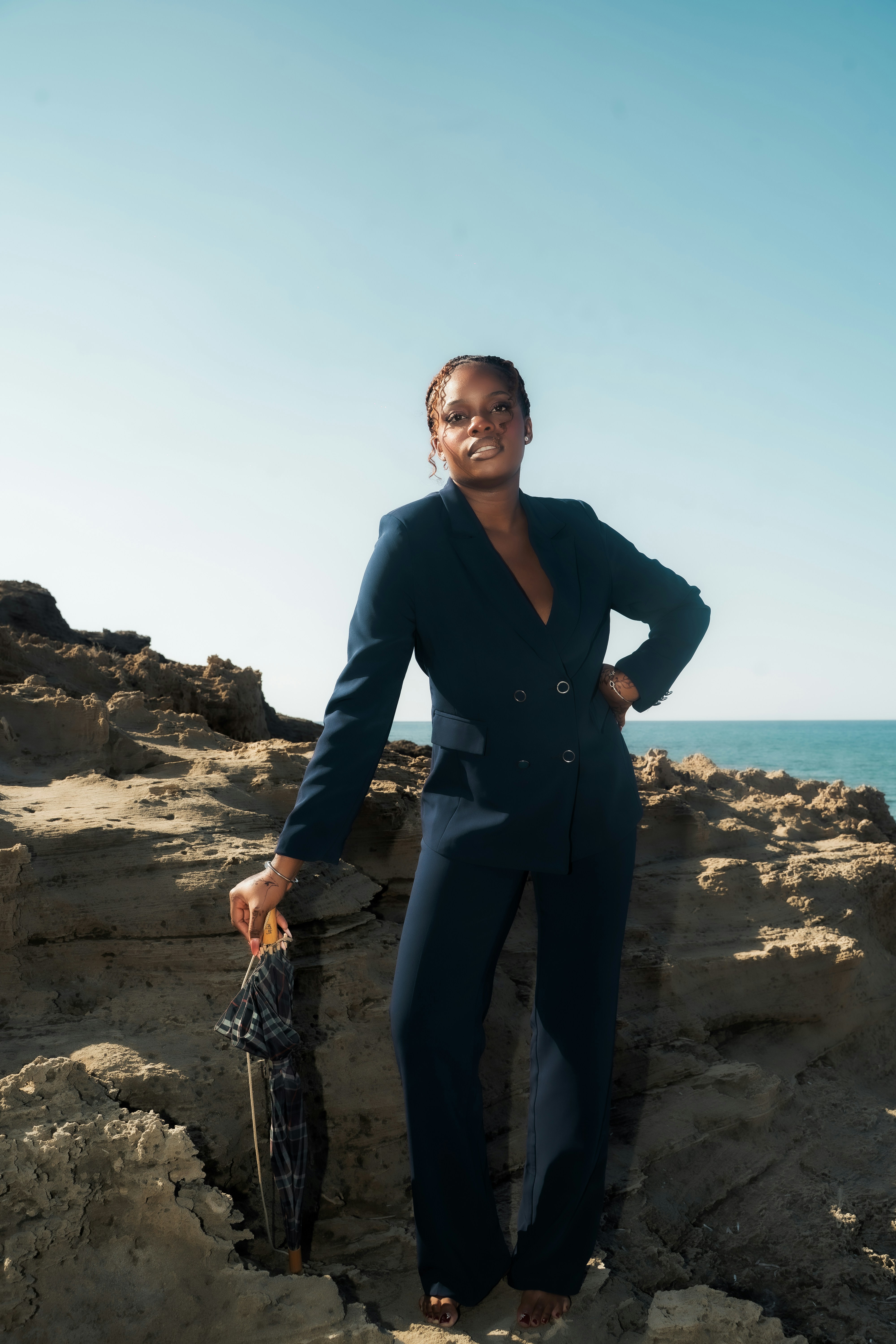 Coastline Command: Navy Suit on Rugged Rocks