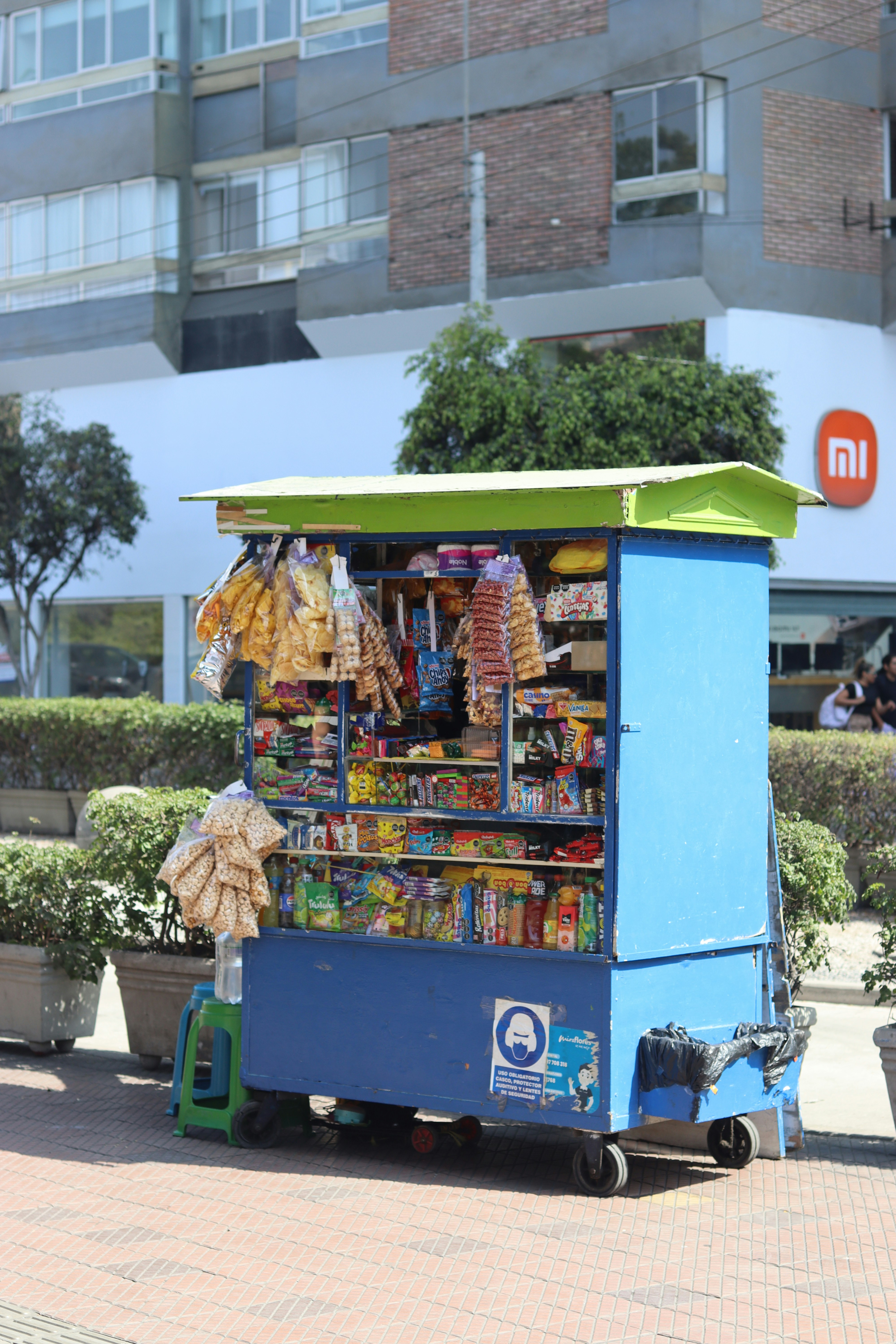Blue Street Snack Cart with a Lime Roof in a Sunlit City Plaza