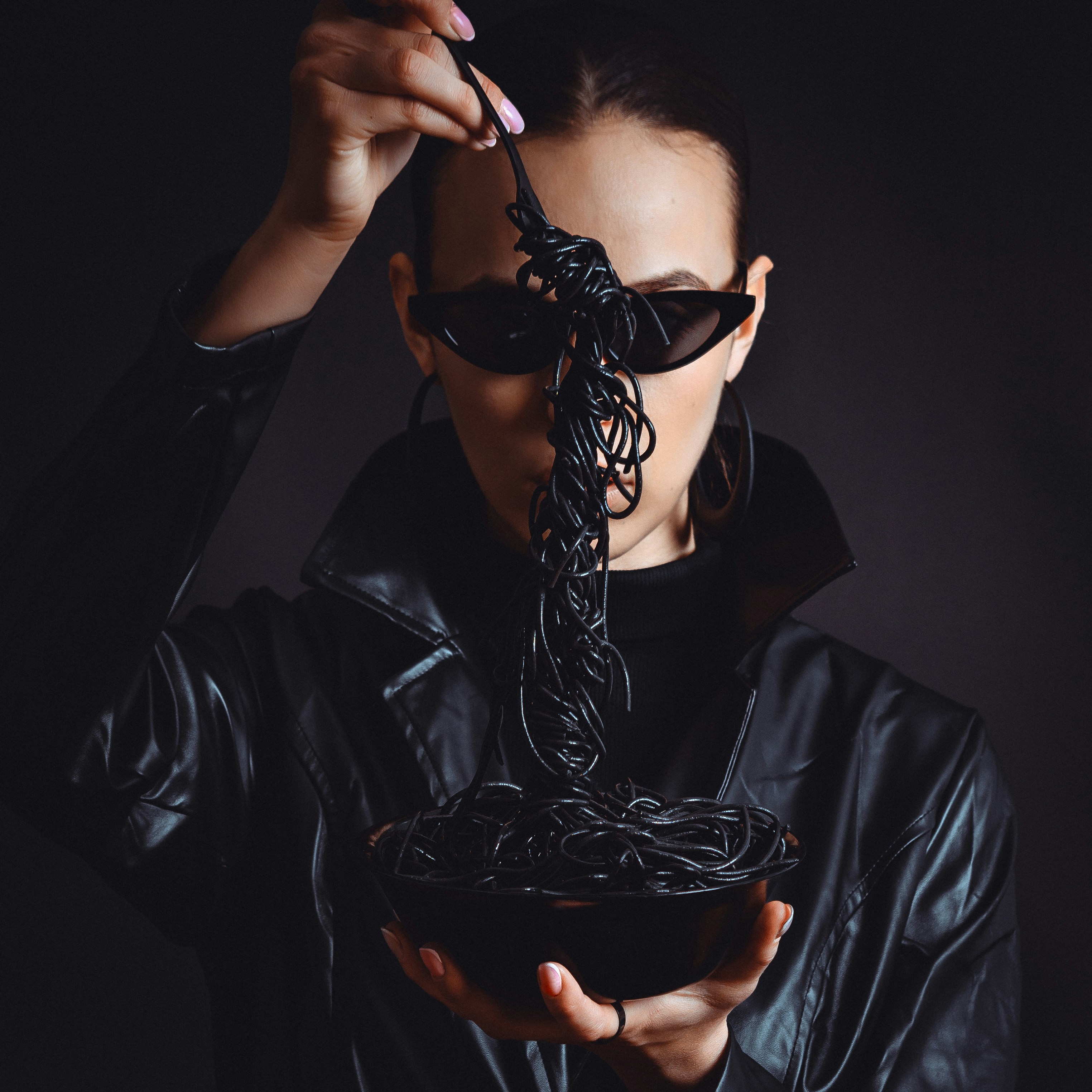 Noir Noodles: Leather-Clad Portrait Weaving Squid-Ink Tangle