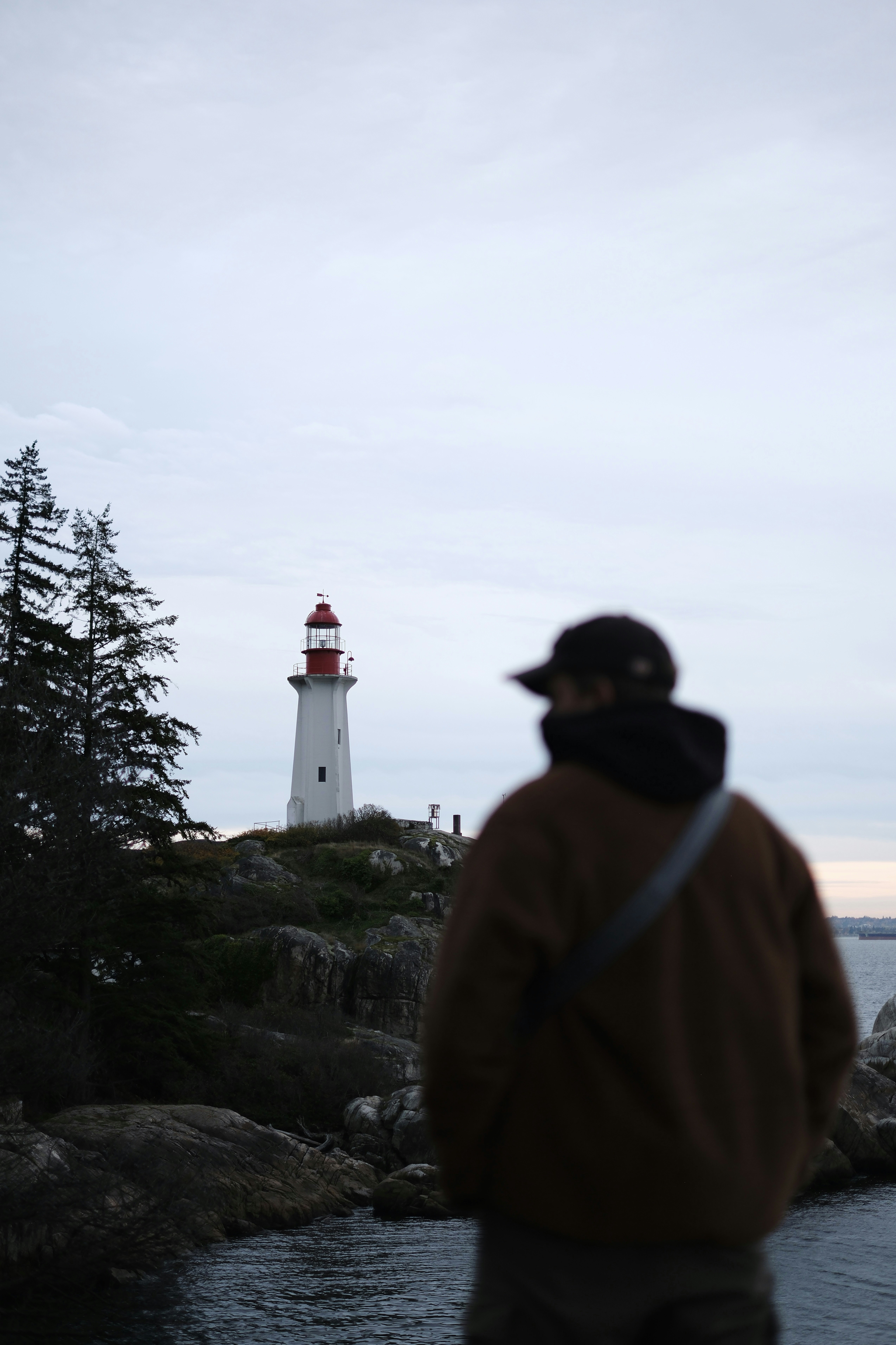 Lighthouse on the Edge of Calm: a Blurred Foreground Watcher Peers Toward the Horizon