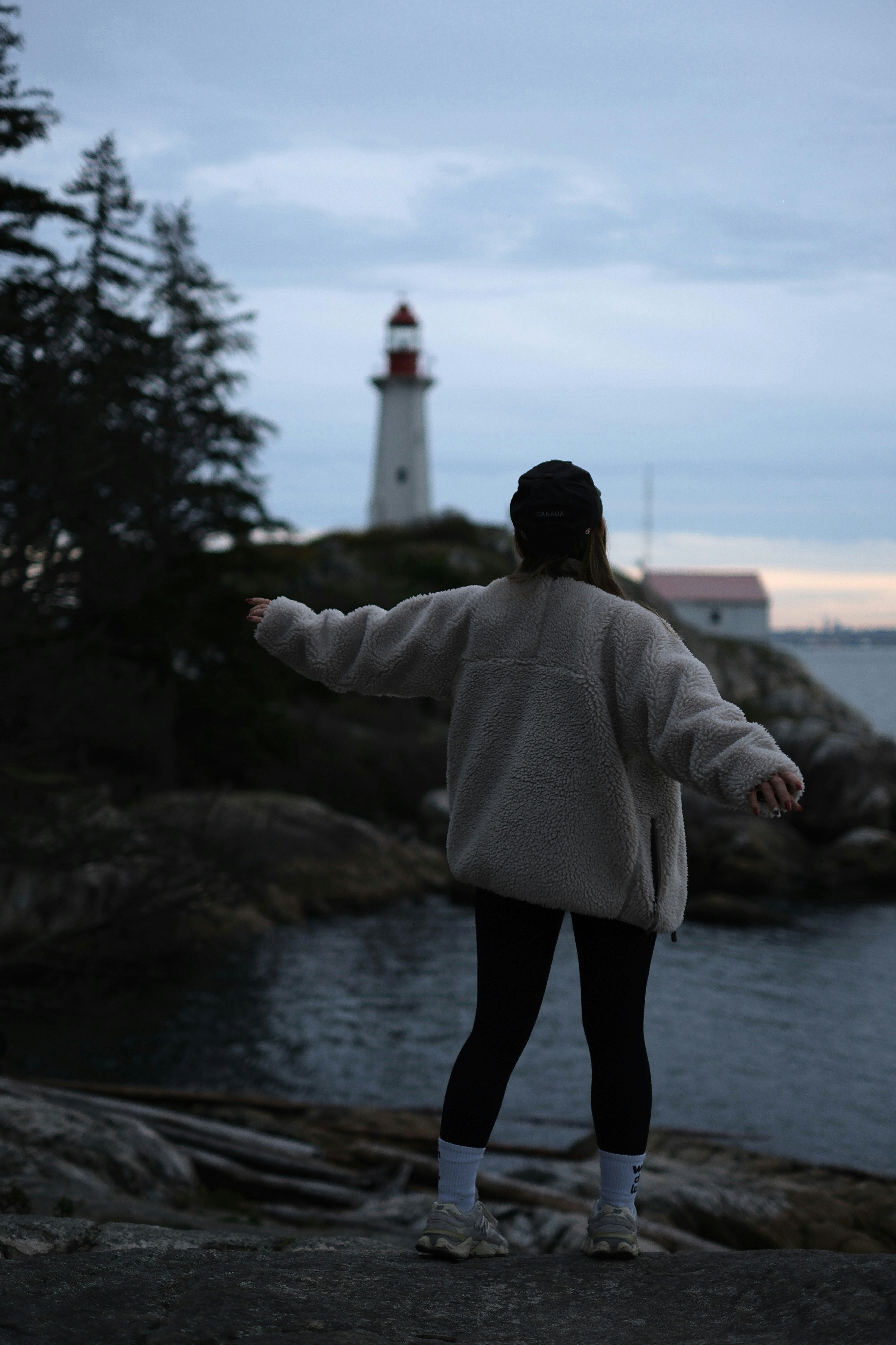 Arms Open to the Sea: A Figure Embracing the Lighthouse at Dusk