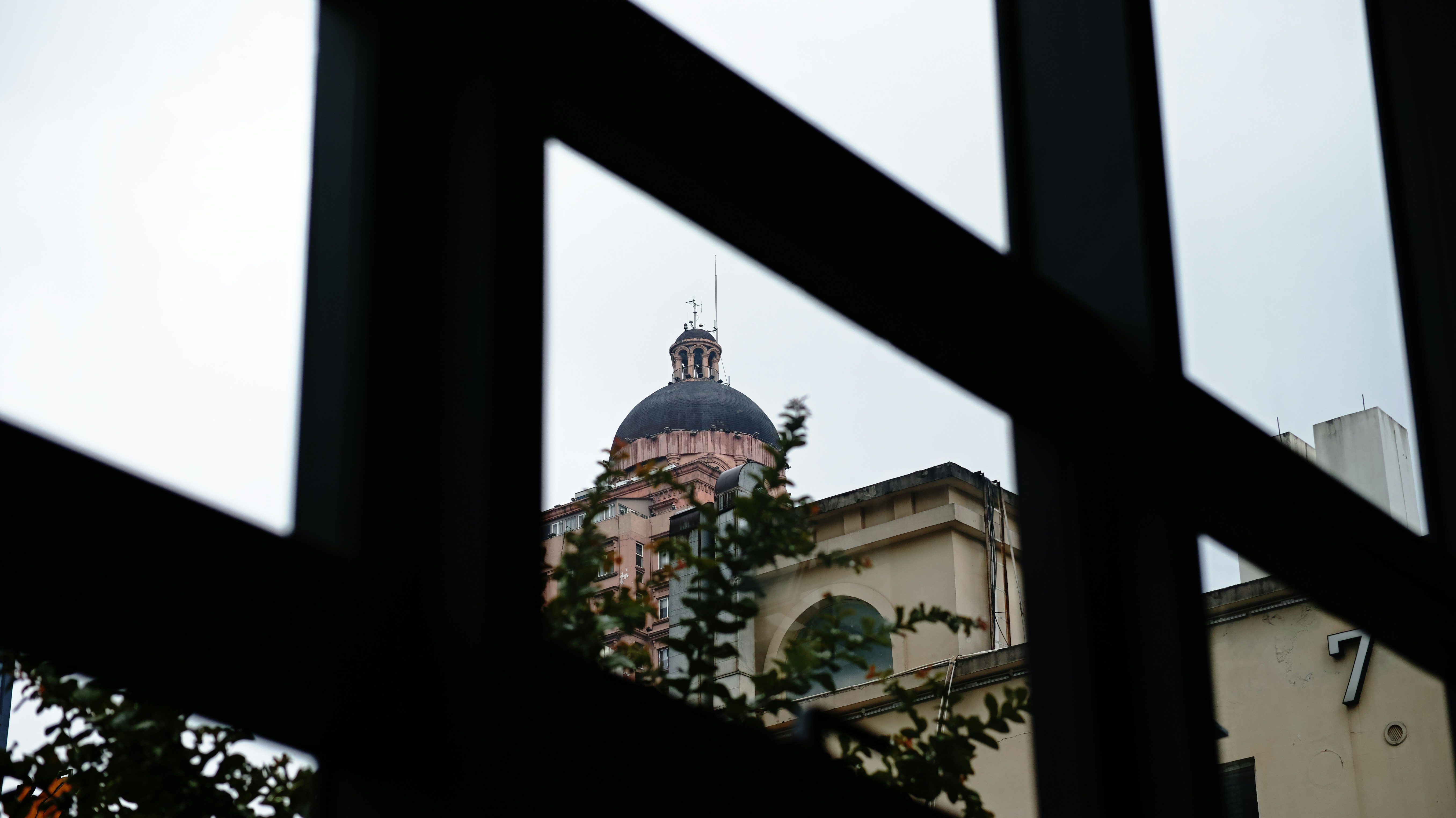 A dome building seen through a dark metal grate.