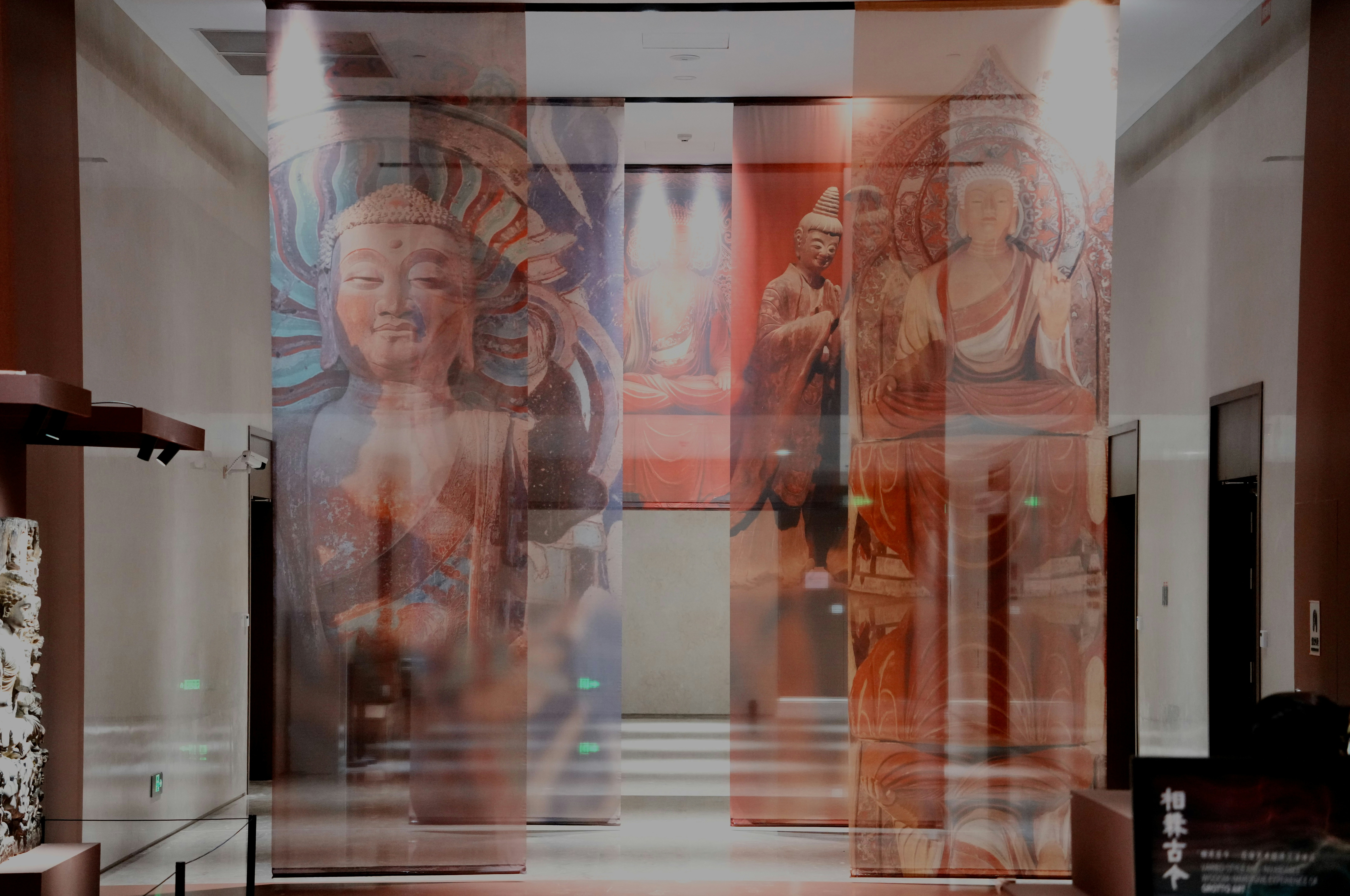 Blurred Reverence: Red Banners in a Quiet Buddhist Gallery