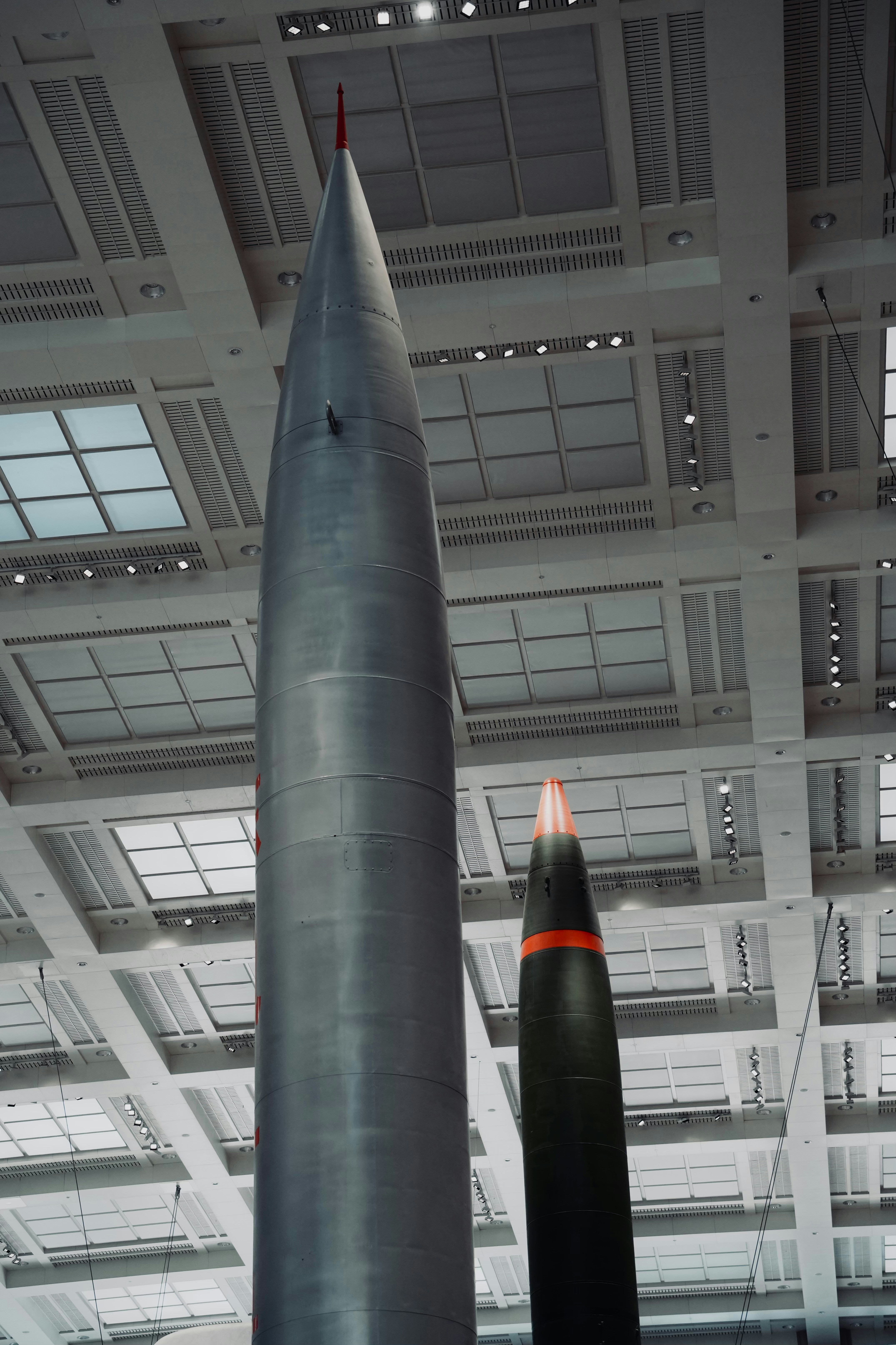 Vertical Colossi: Twin Missiles Rise Inside a Grid-Walled Exhibition Hall