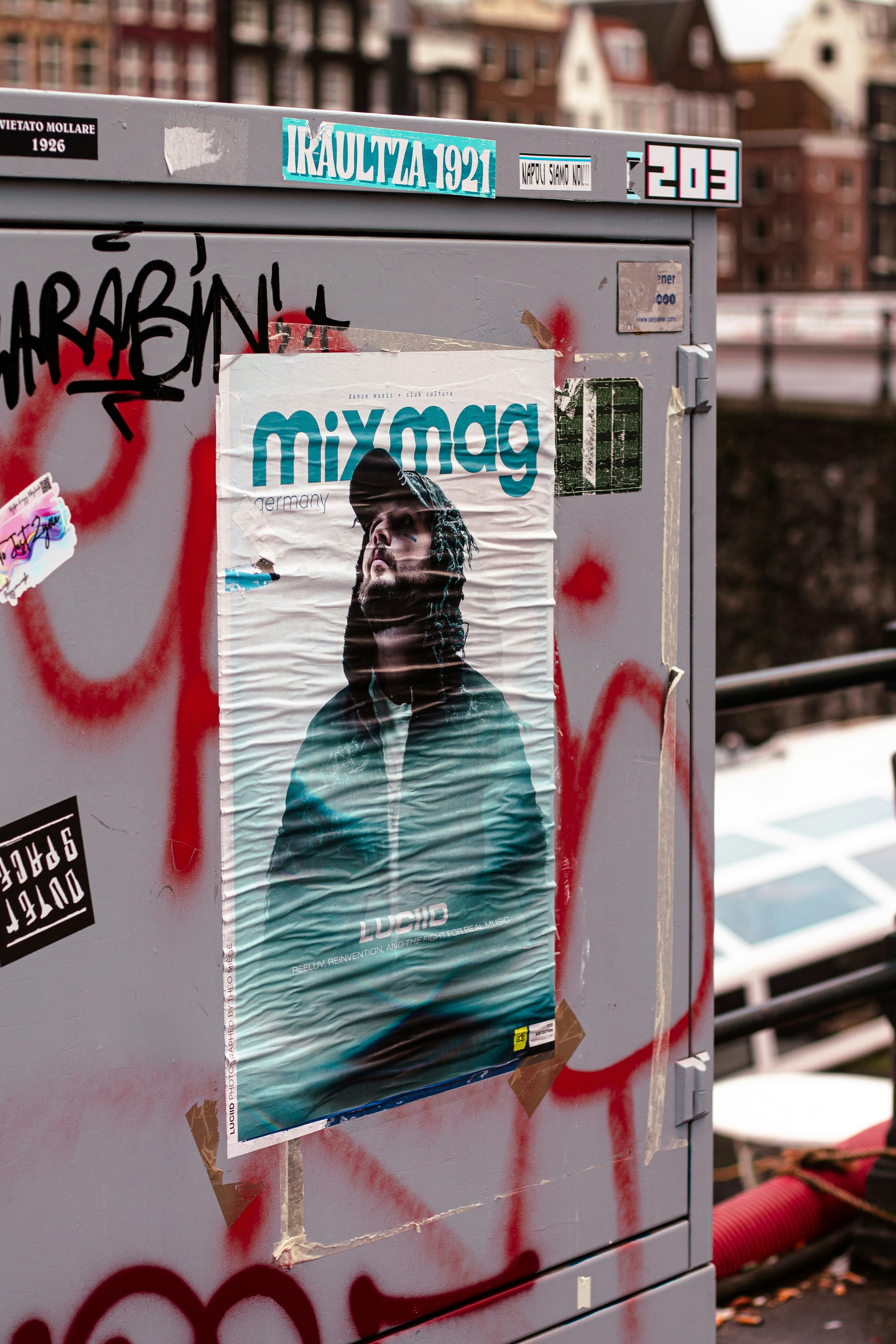 Mixmag Poster on a Graffiti-Slashed Utility Box