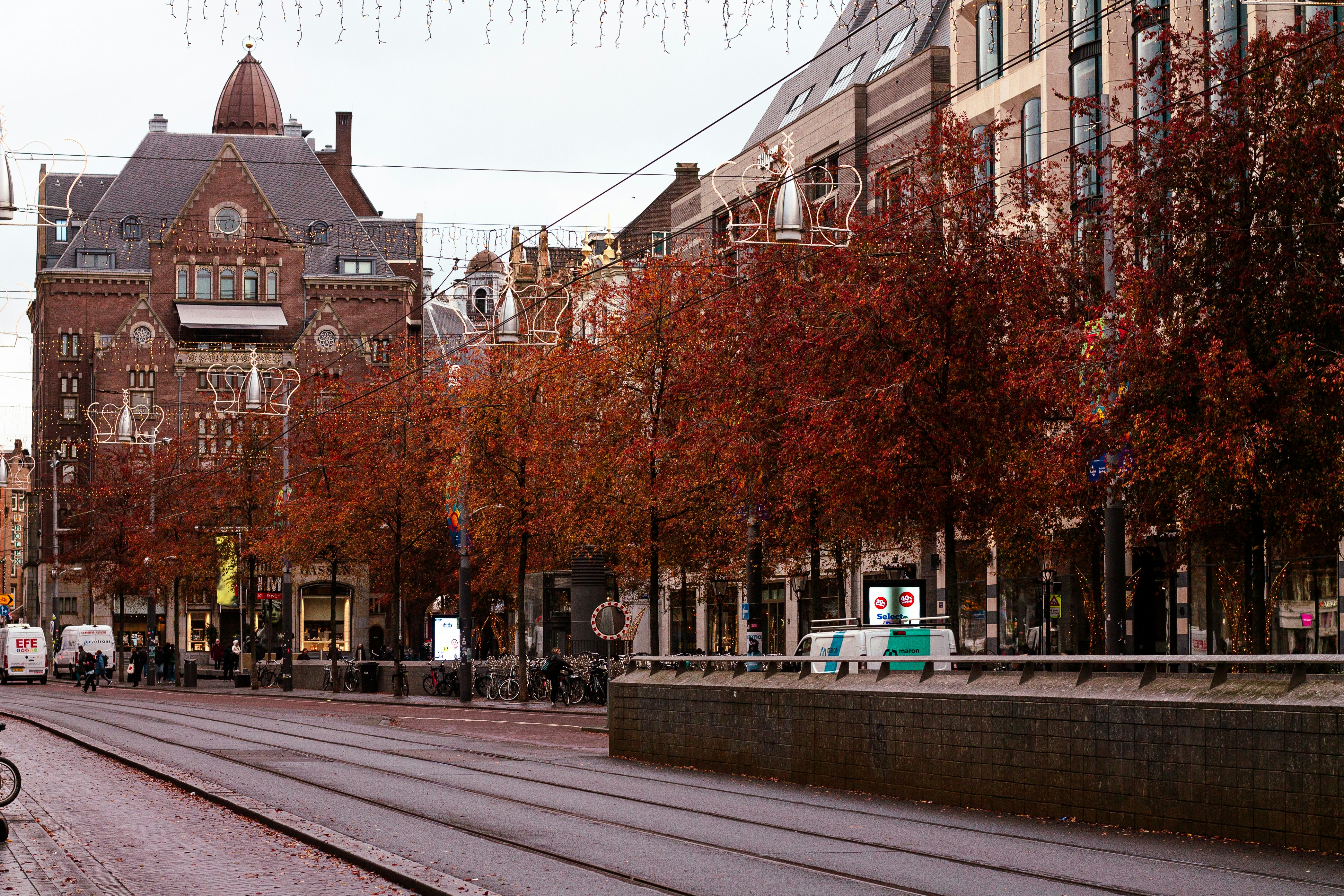 Crimson Canopy Over a Historic City Street by Tram Tracks
