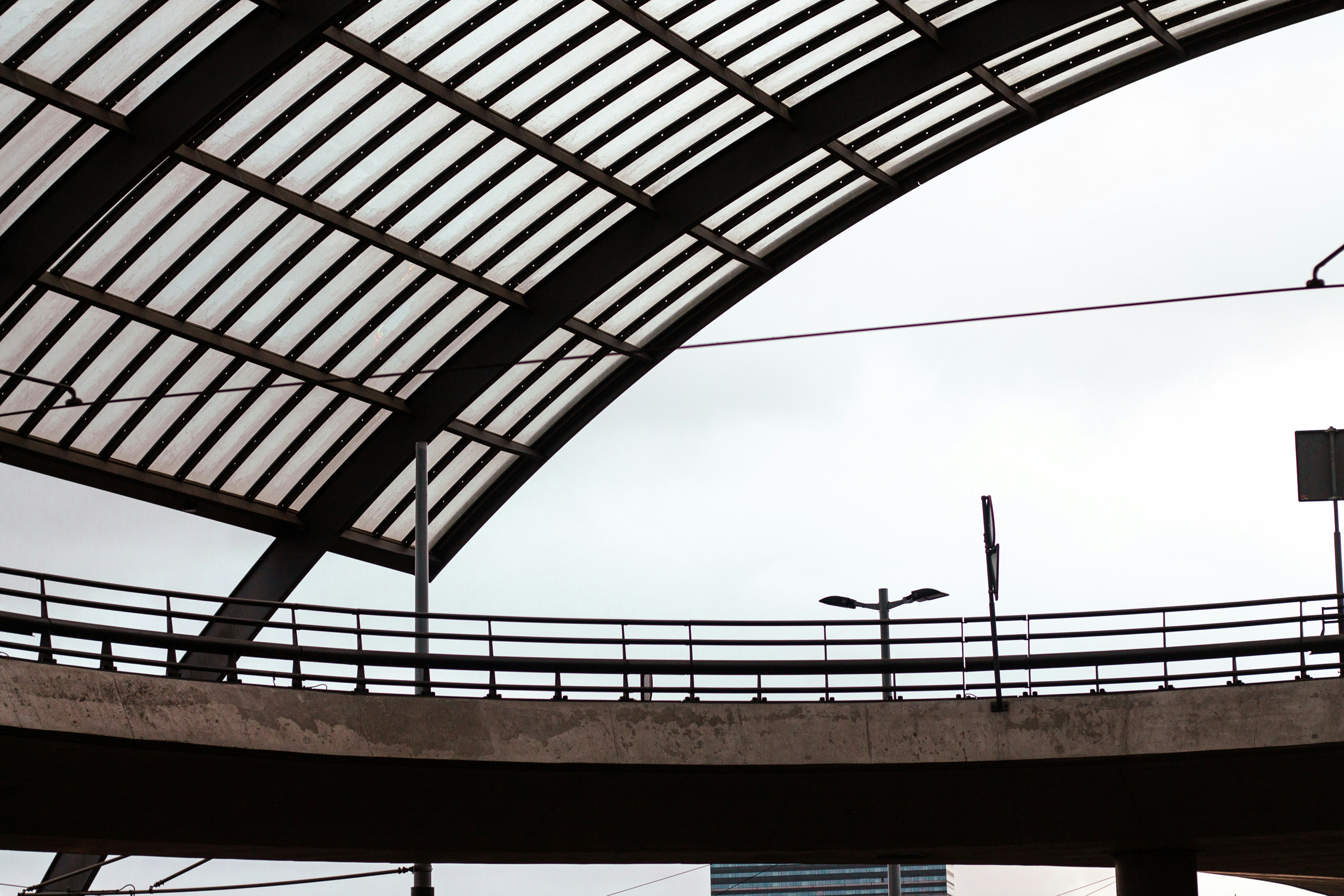 Arcade of Steel and Glass: A Ribbed Canopy Framing a Quiet Urban Curve