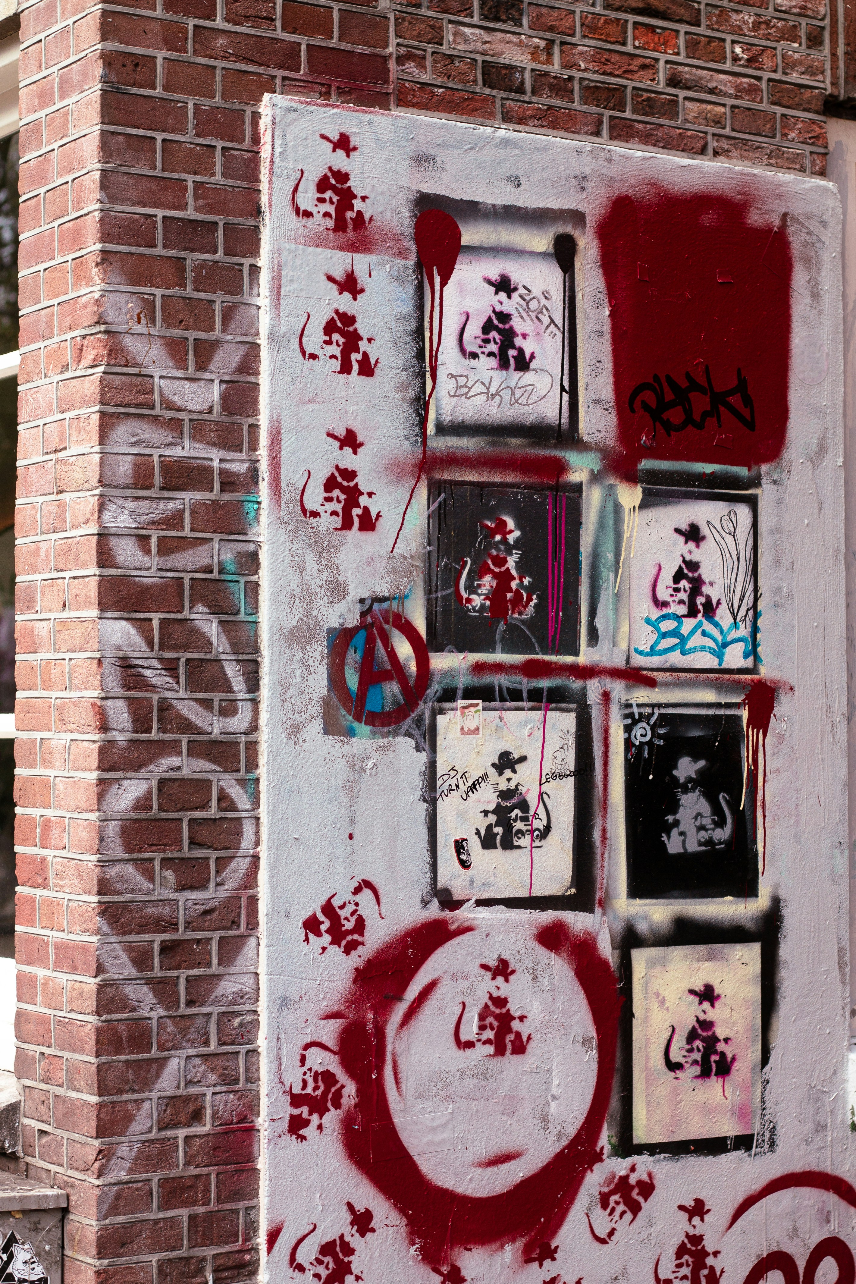 Red Circular Target Anchors a Graffiti Grid on a Weathered Brick Panel