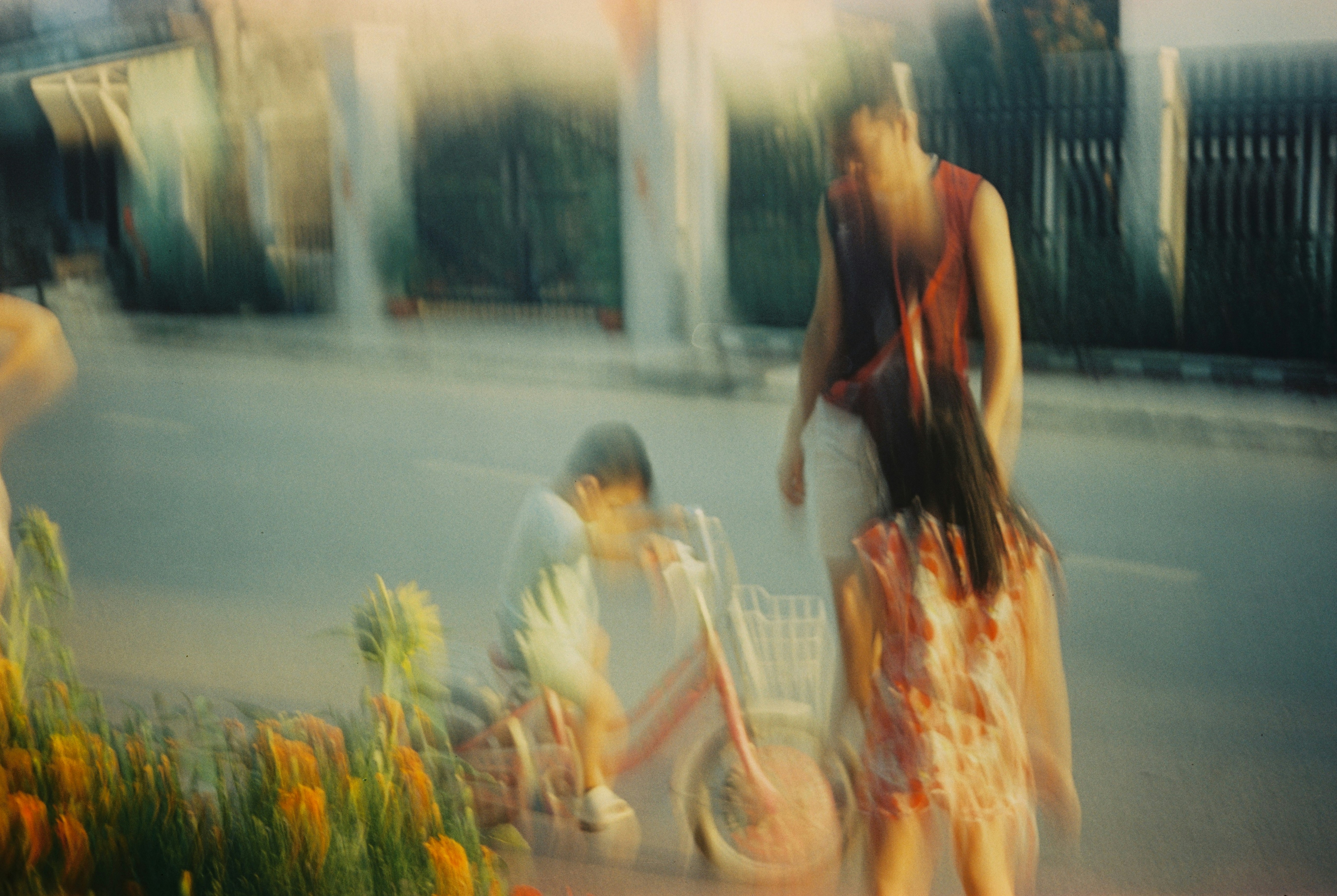 Sunlit Blur on the Sidewalk: A Child on a Scooter Amid Moving Pedestrians