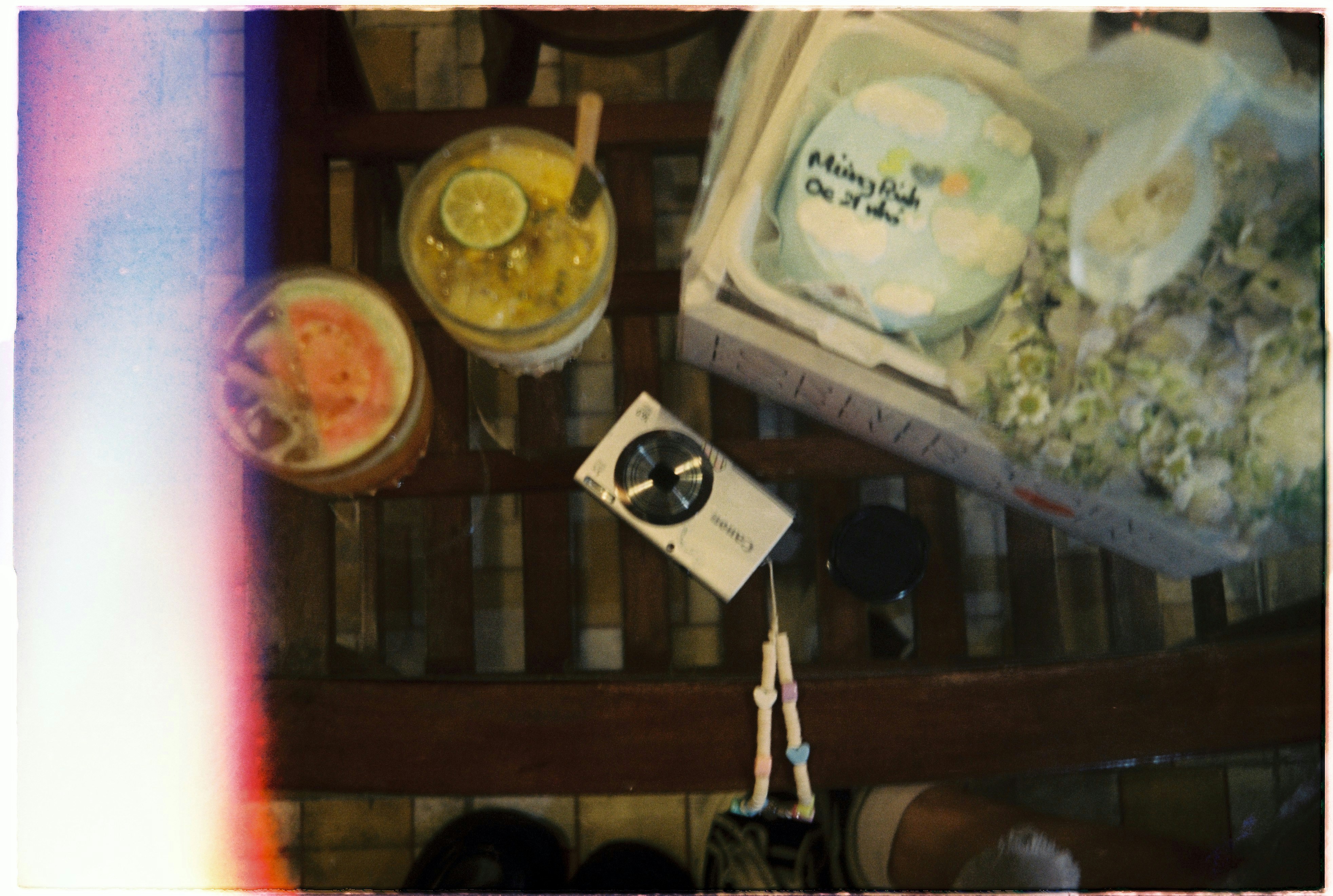 Overhead Café Still Life: Citrus Drinks, Boxed Cake, and a Tiny Camera Centerpiece