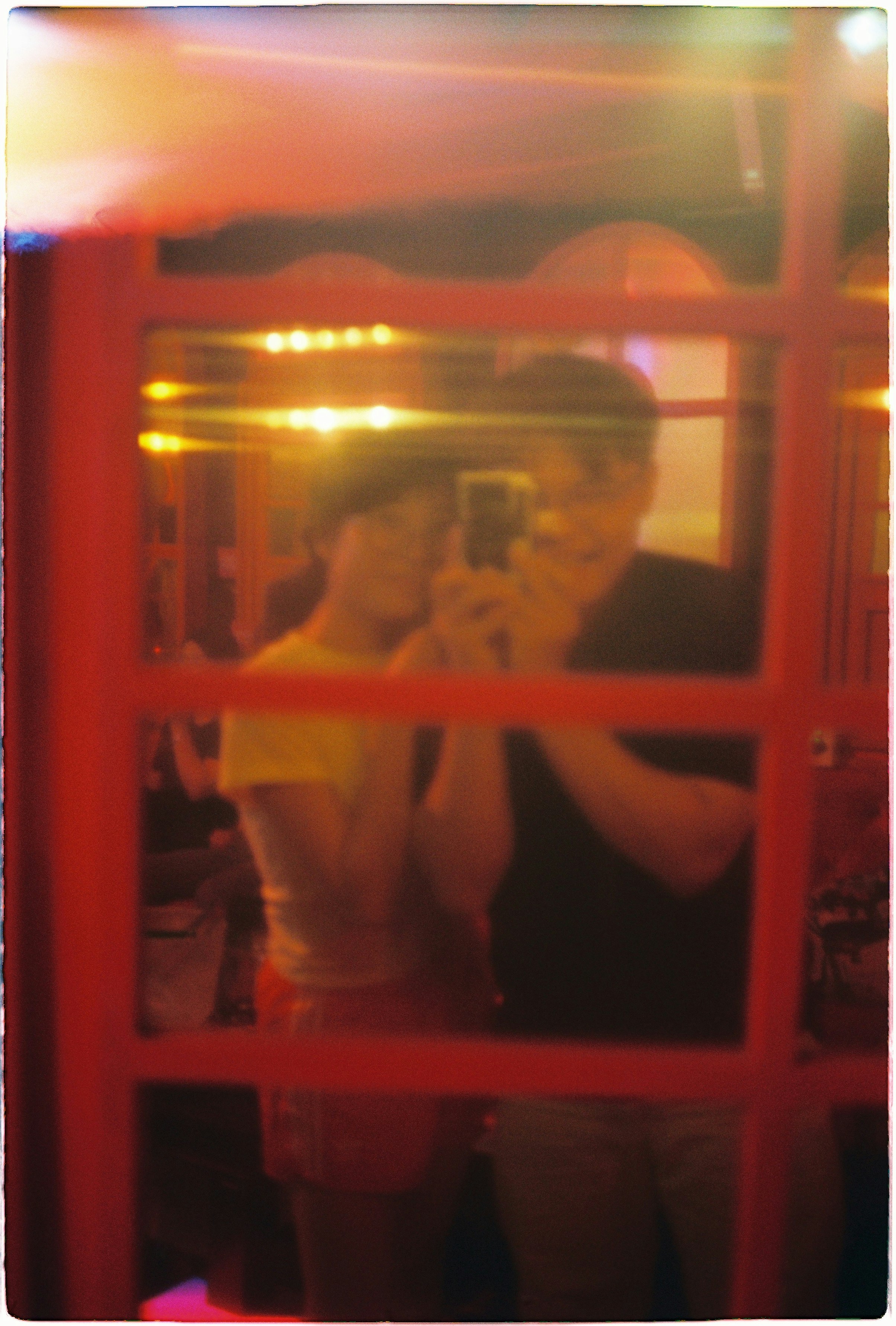 Red Grid Reflections: A Neon Selfie in a Glass Box