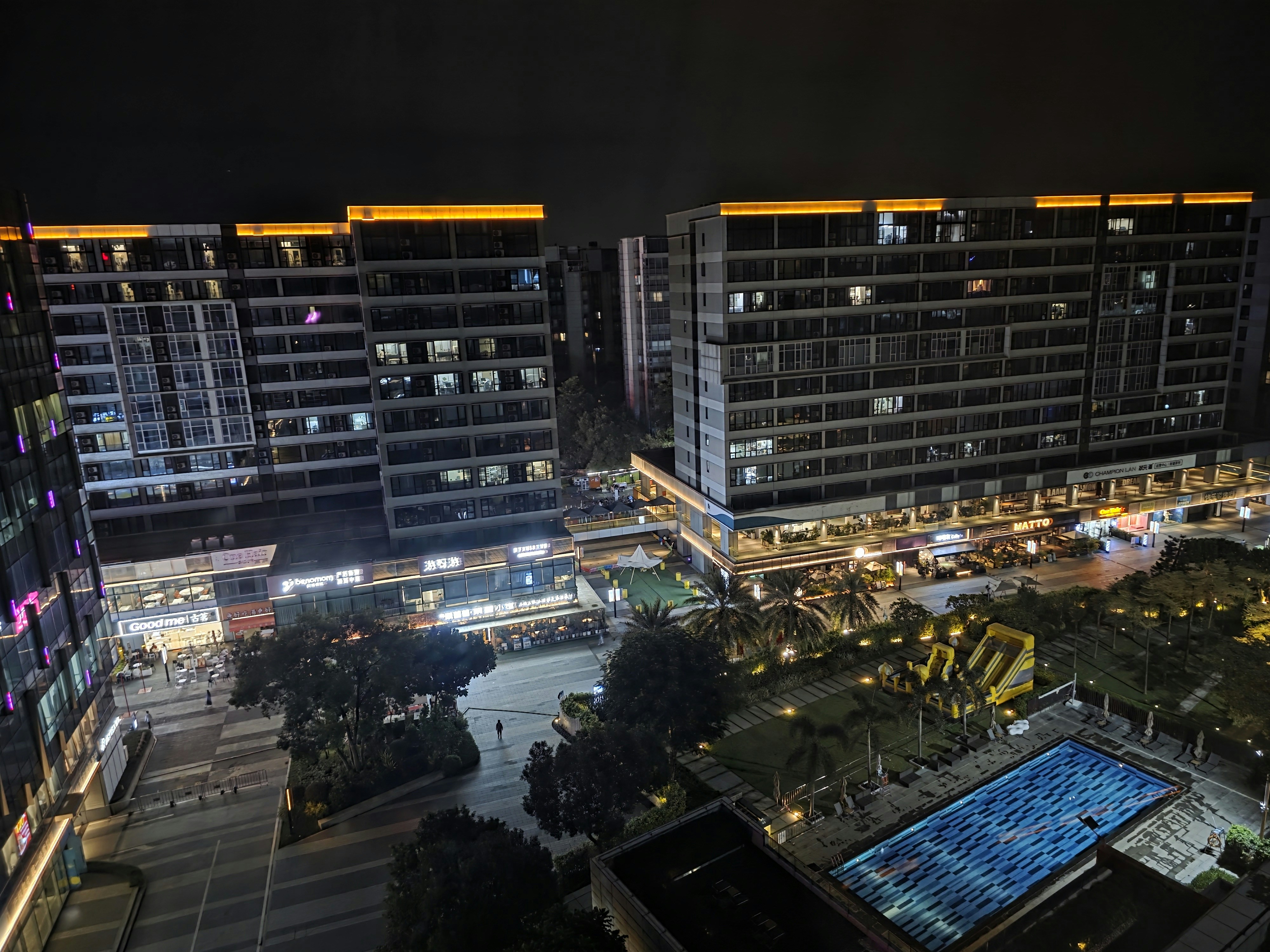Modern buildings illuminated at night with city lights.