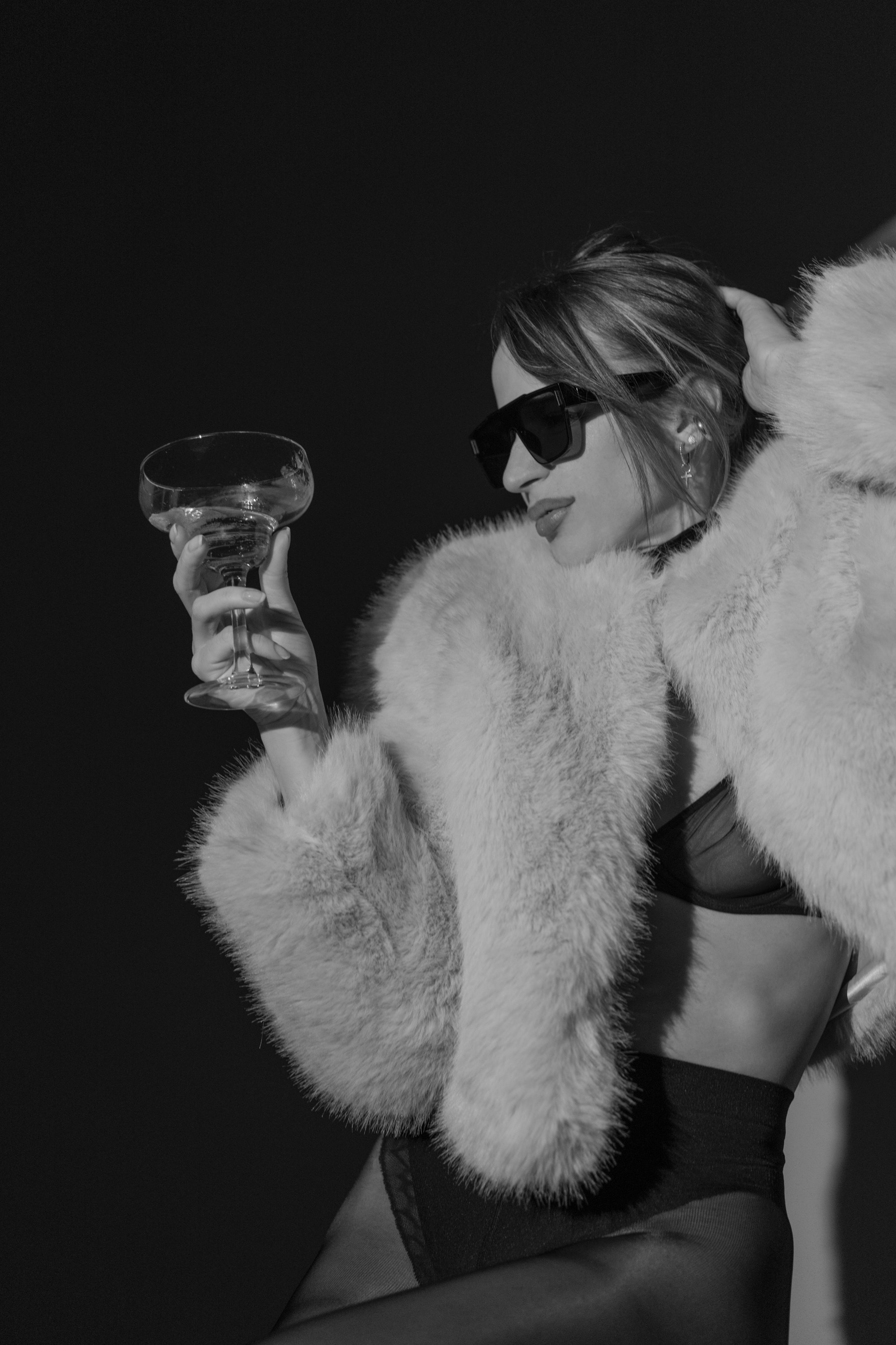 Glamour in Noir: A Glass, Fur, and Shadowed Confidence