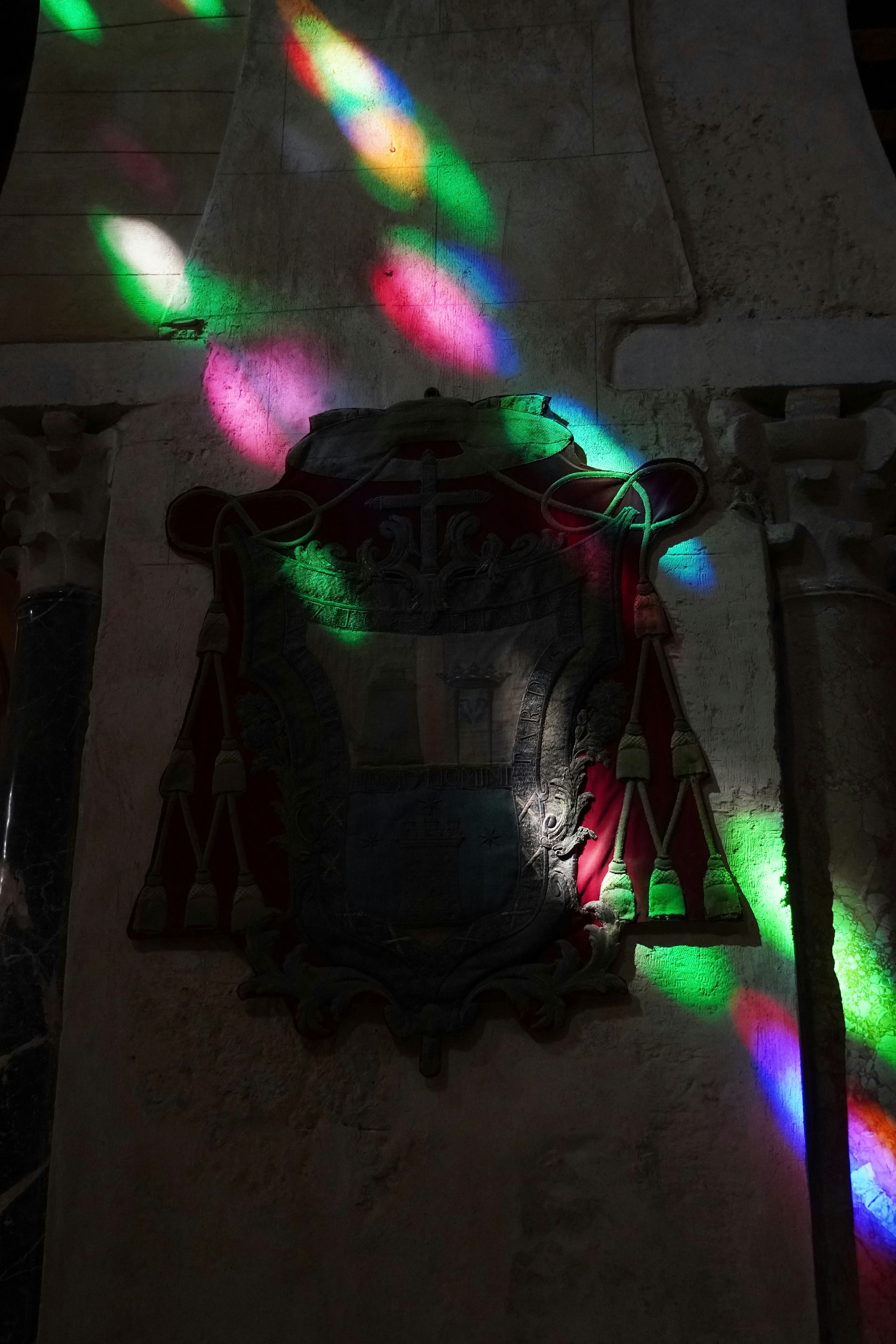 Rainbow Specks on a Stone Crest: A Shield Bathed in Prism Light