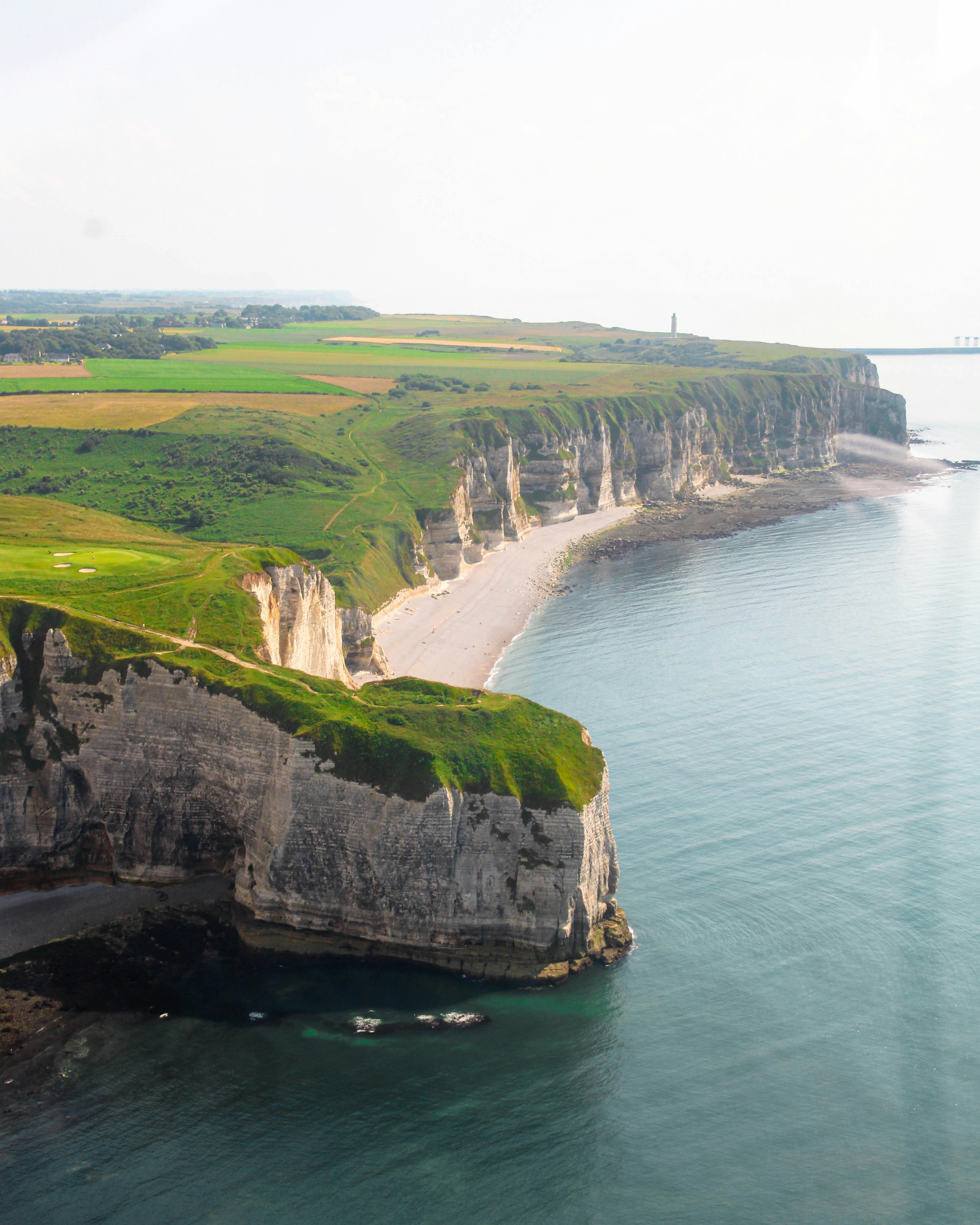 Emerald Cliffs Framing a Calm, Curving Coastline