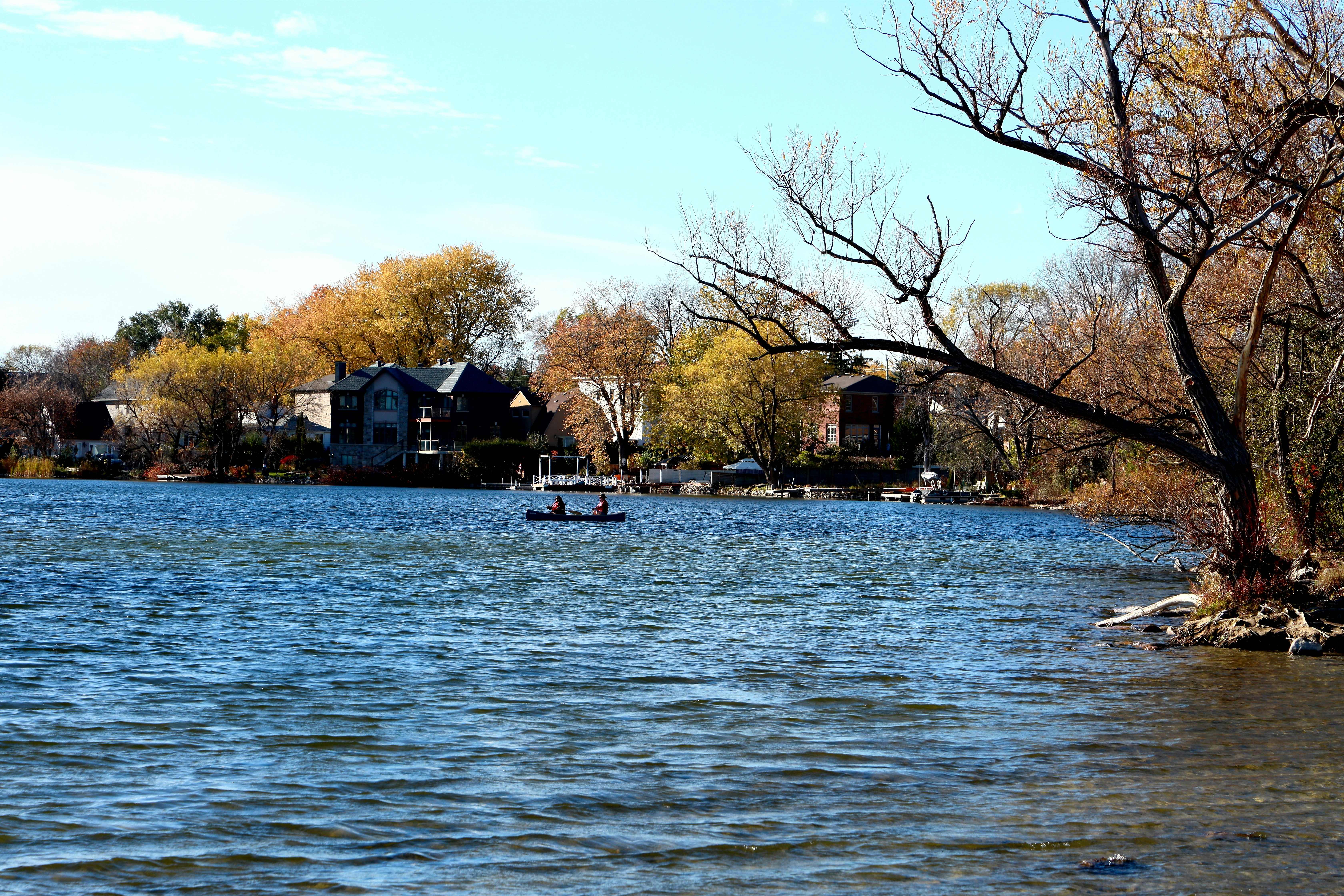 Lone Canoe on Autumn Lake: Quiet Riverside Vista
