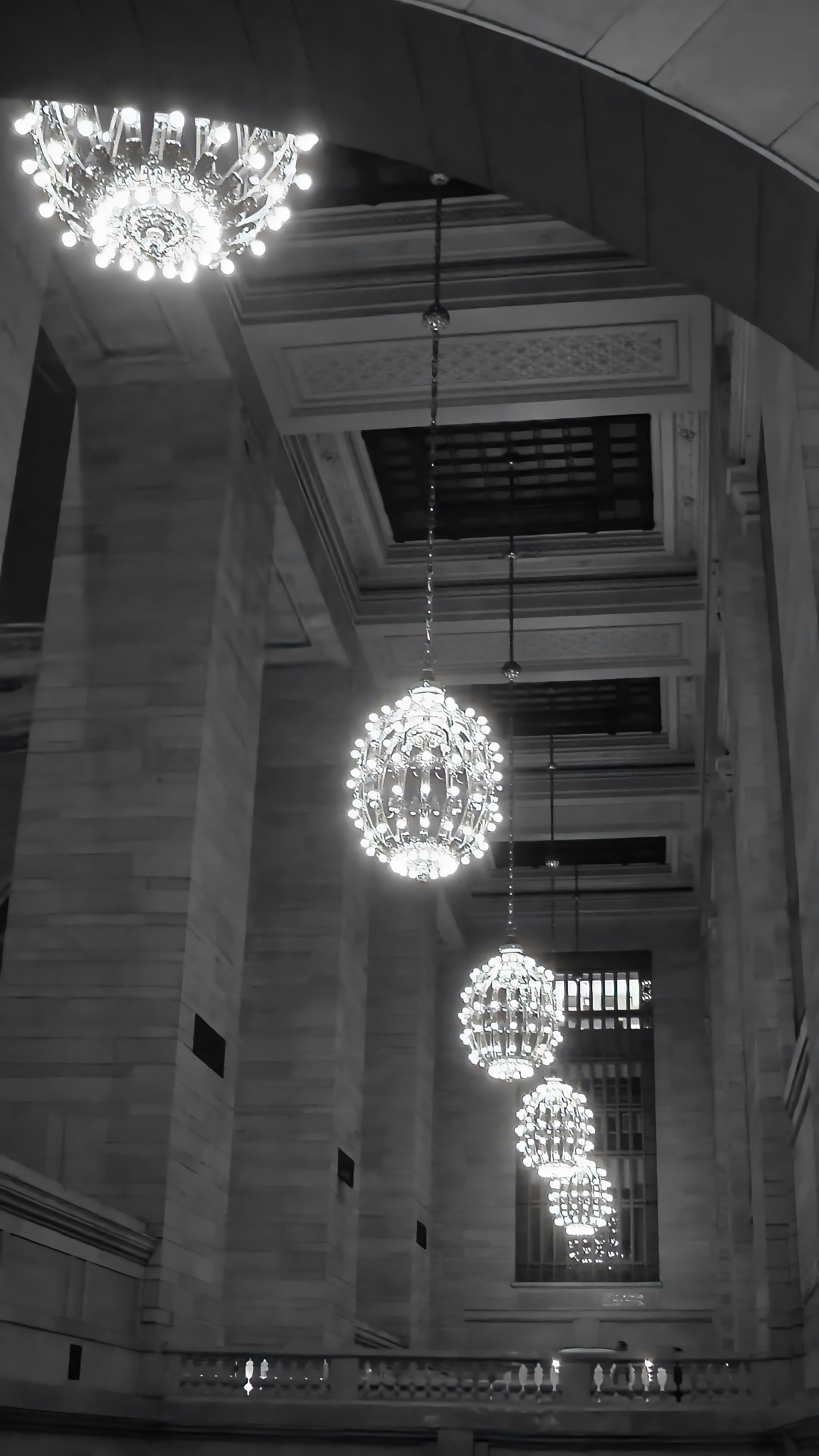 Ornate chandeliers hang in a grand, arched hall.